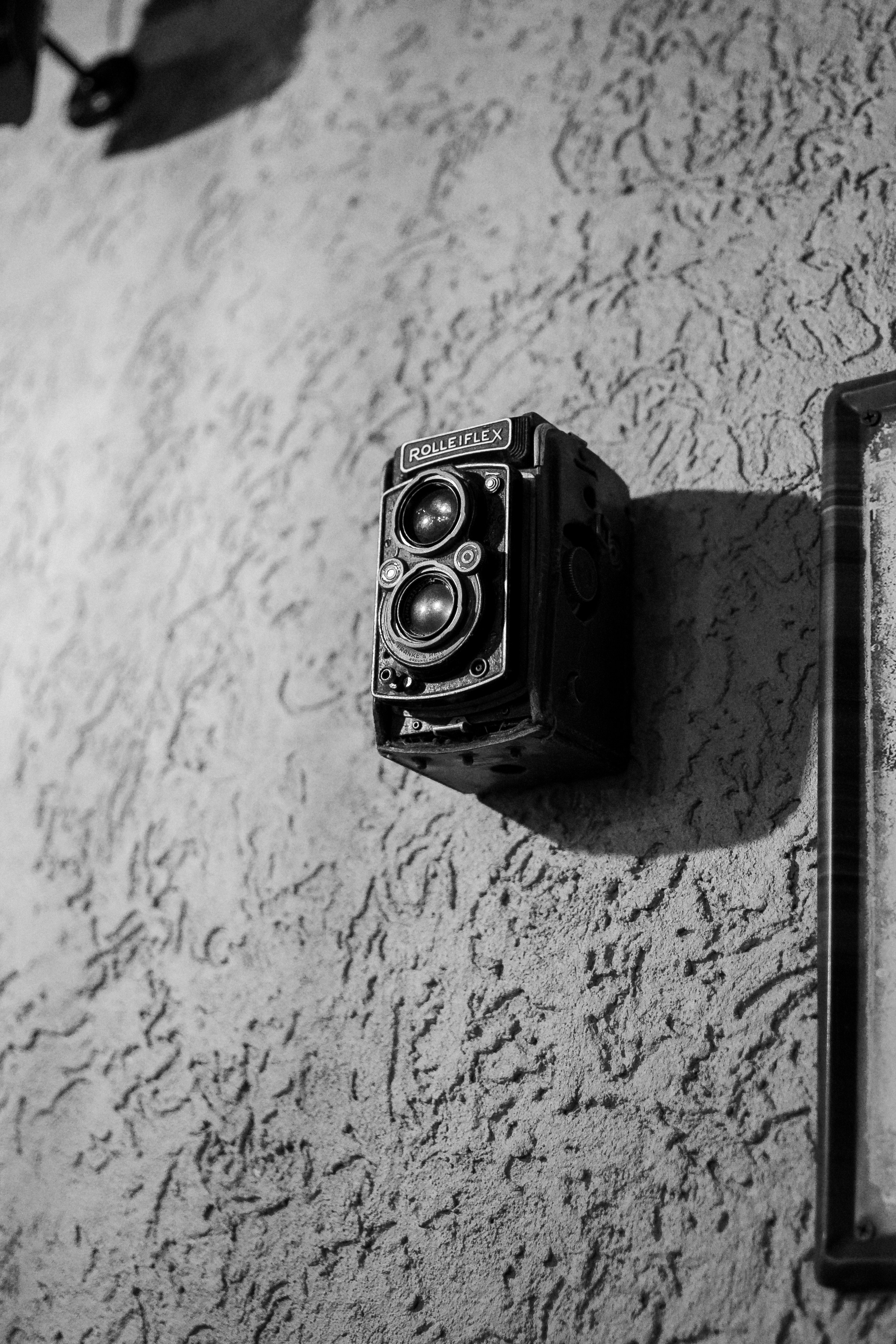 Time-worn Rolleiflex on a textured plaster wall