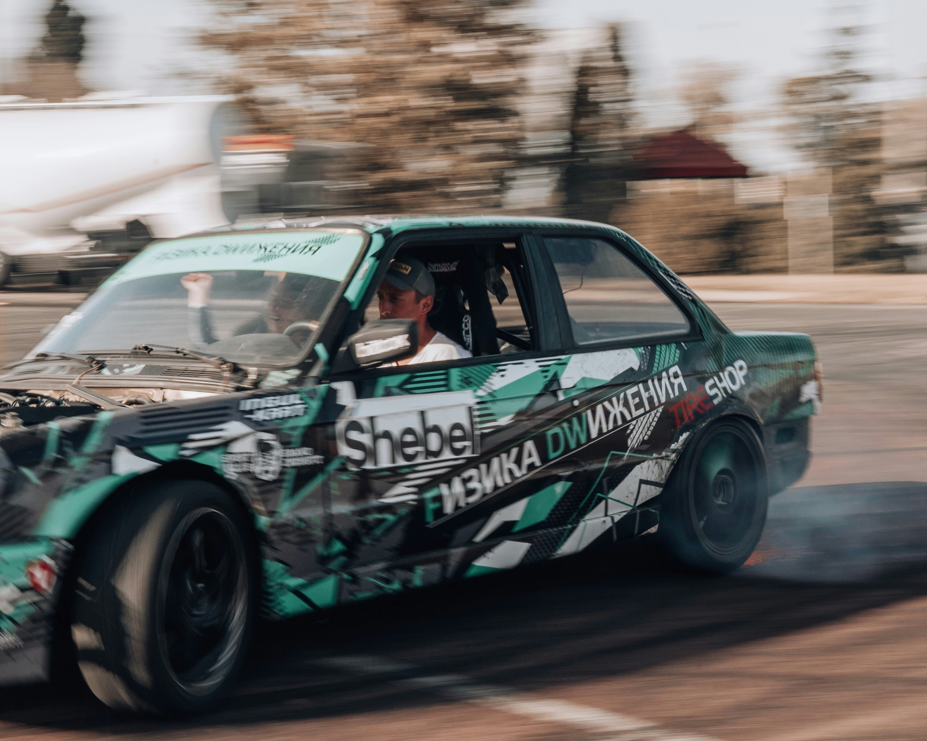Graffiti-laced drift: a turquoise race truck slides through motion blur