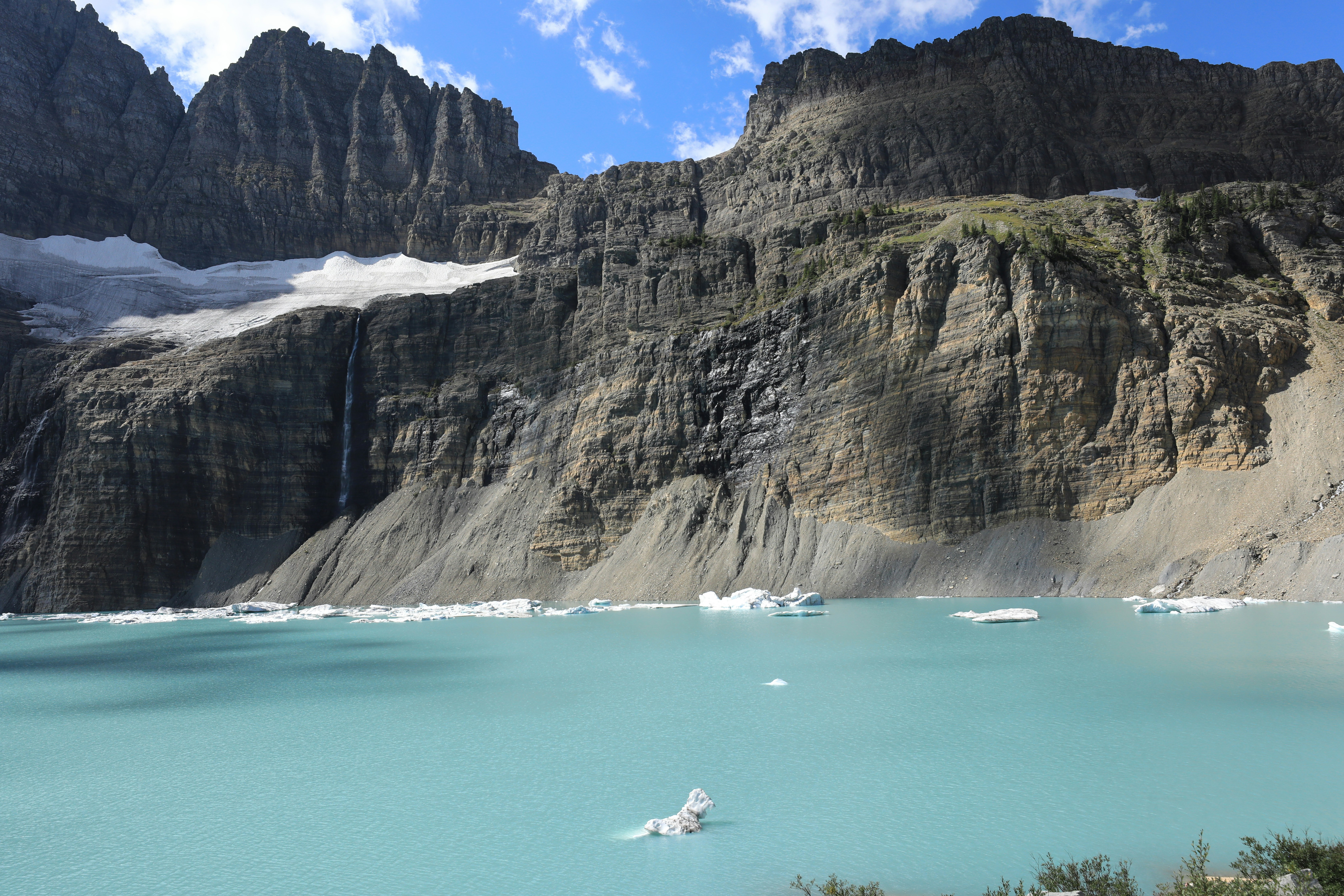 Turquoise Glacier Lake Nestled Between Shadowed Cliffs