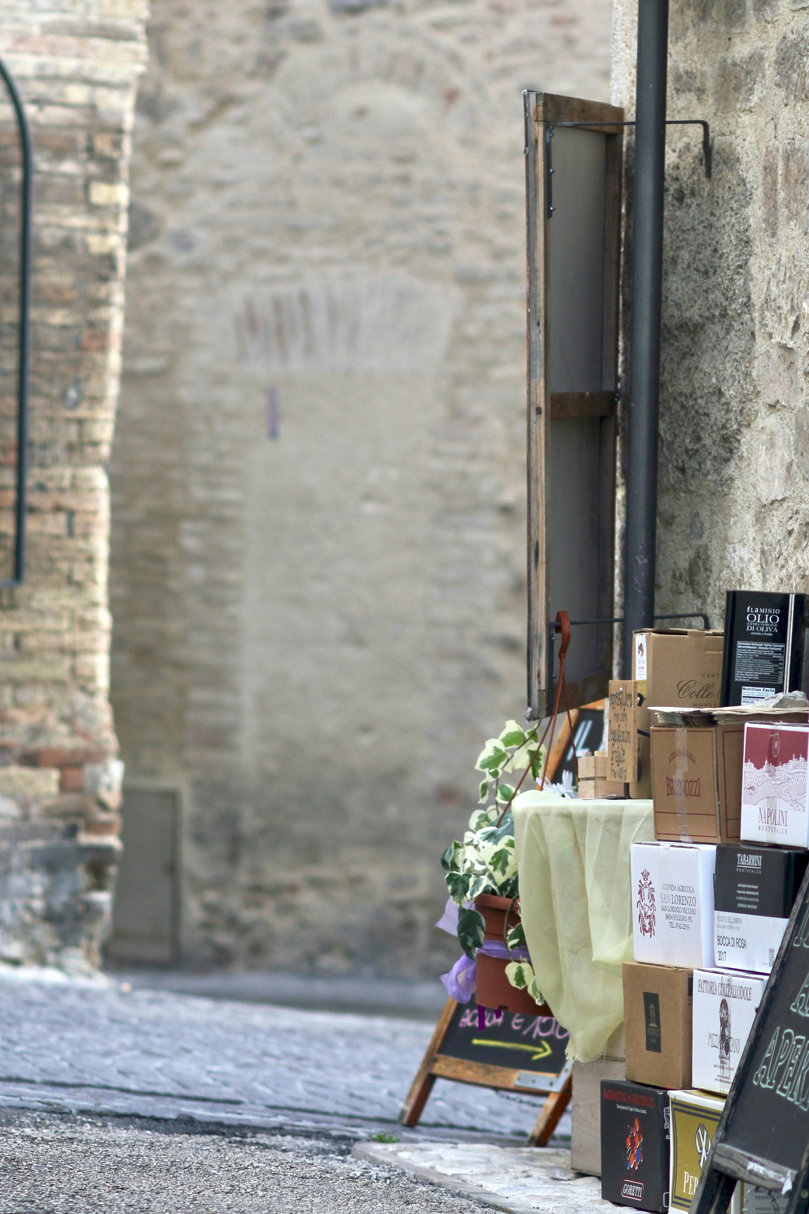 Charming market scene with boxes and greenery nestled in a narrow cobblestone street, showcasing local goods and a rustic ambiance.