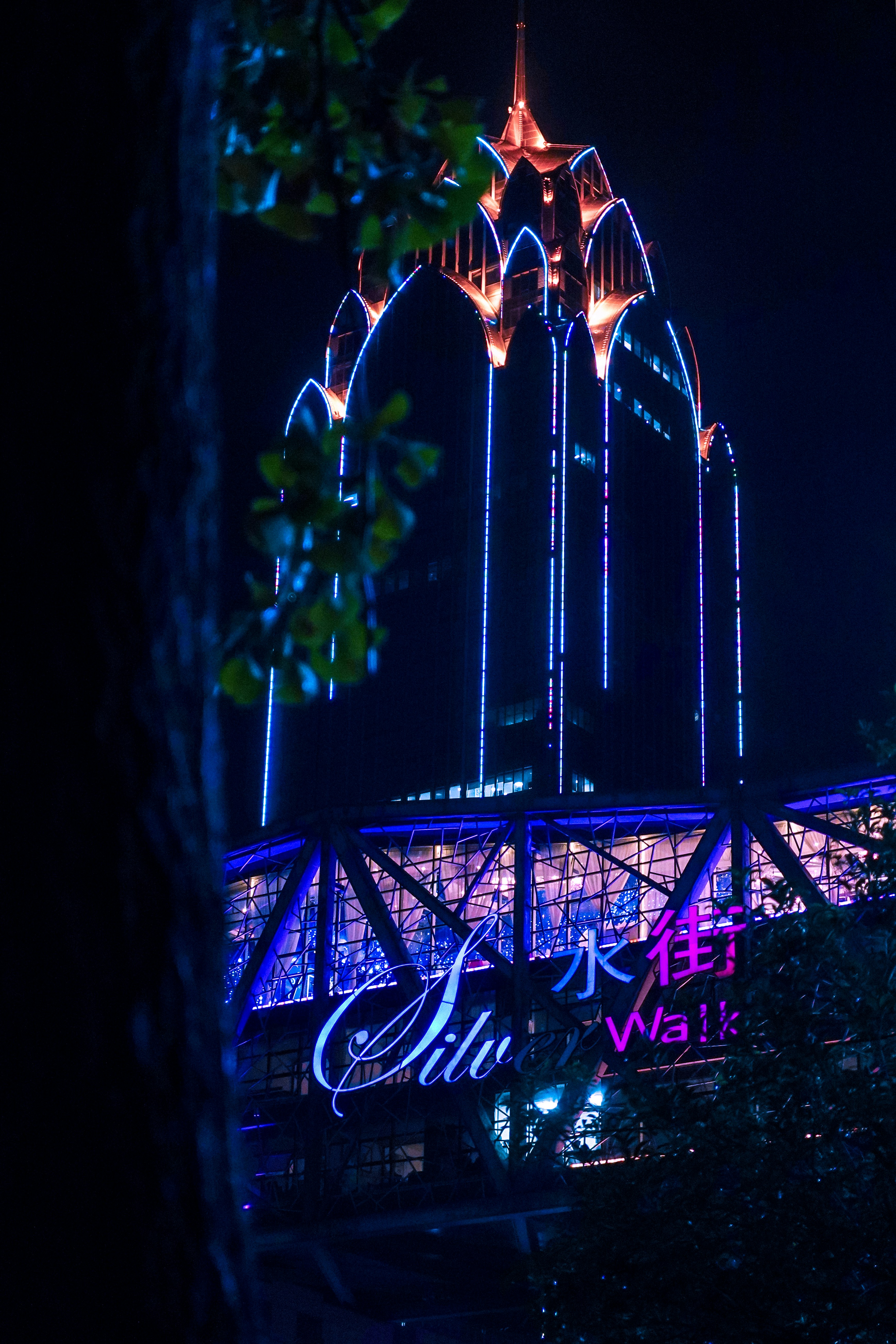 A large building with a lit up sign on it's side photo – Free Lighting ...