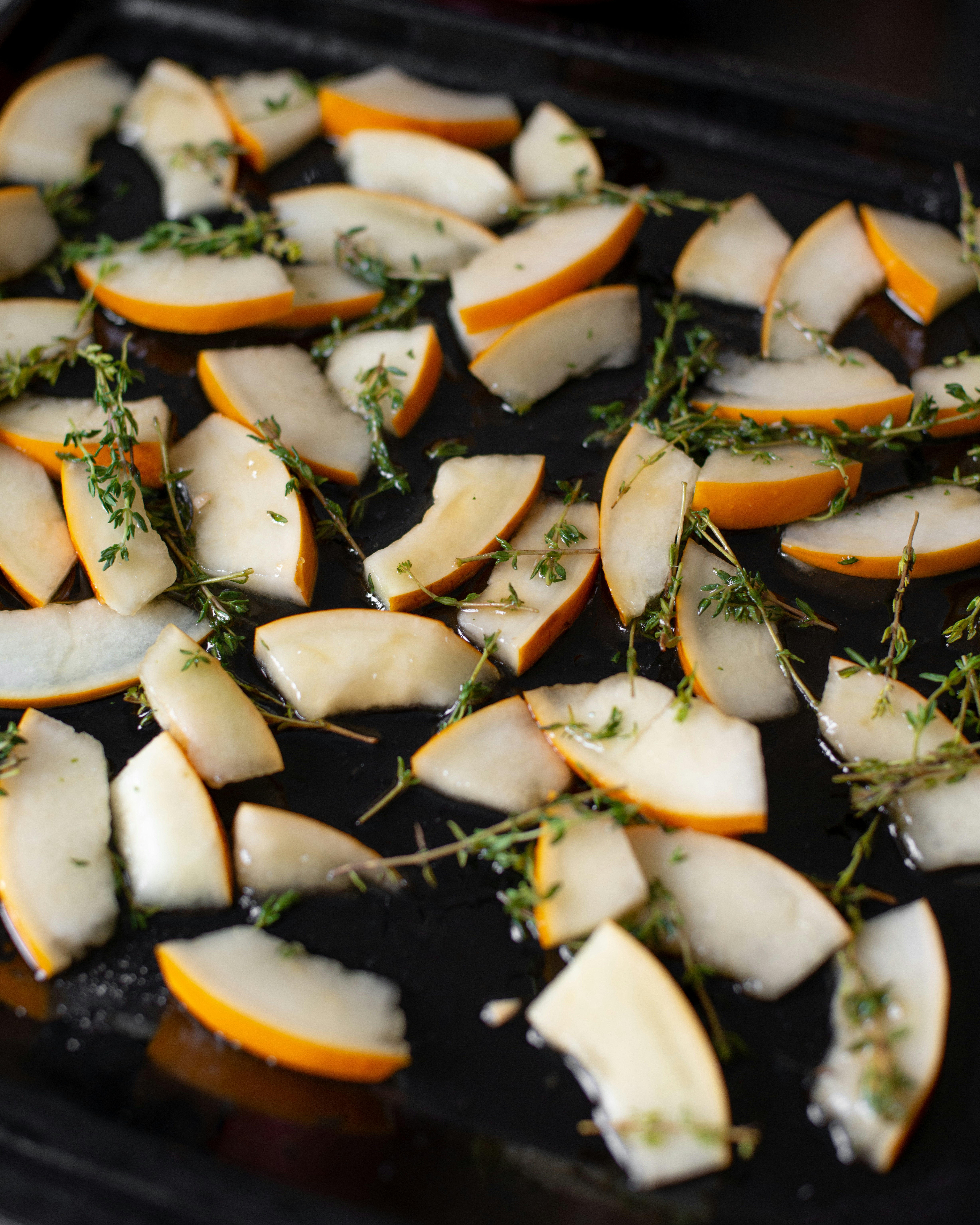 Citrus Confetti: Thyme-Laced Orange Wedges on a Dark Baking Tray
