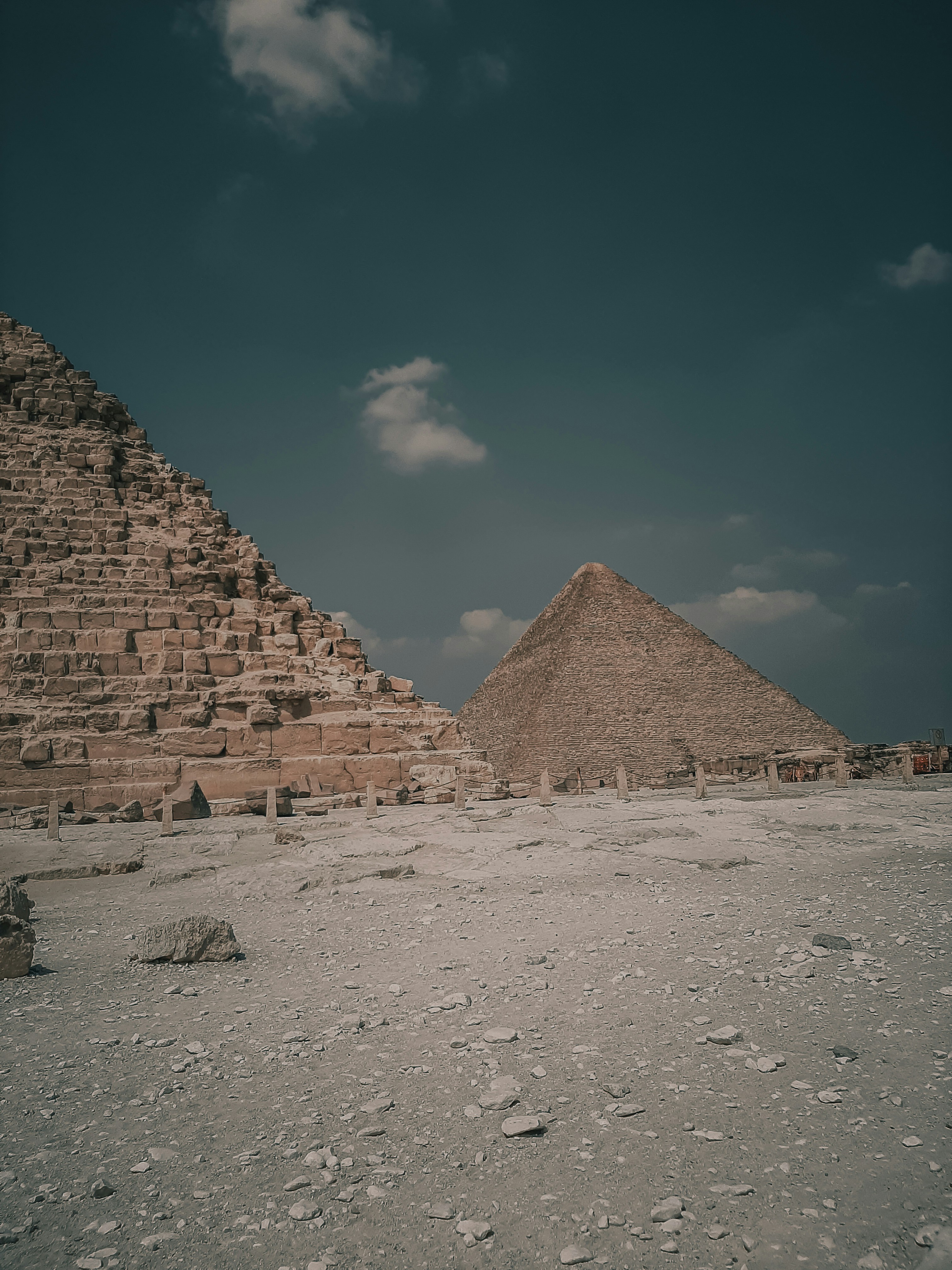Two majestic pyramids rise from the arid landscape under a vast sky, showcasing the grandeur of ancient Egyptian architecture.