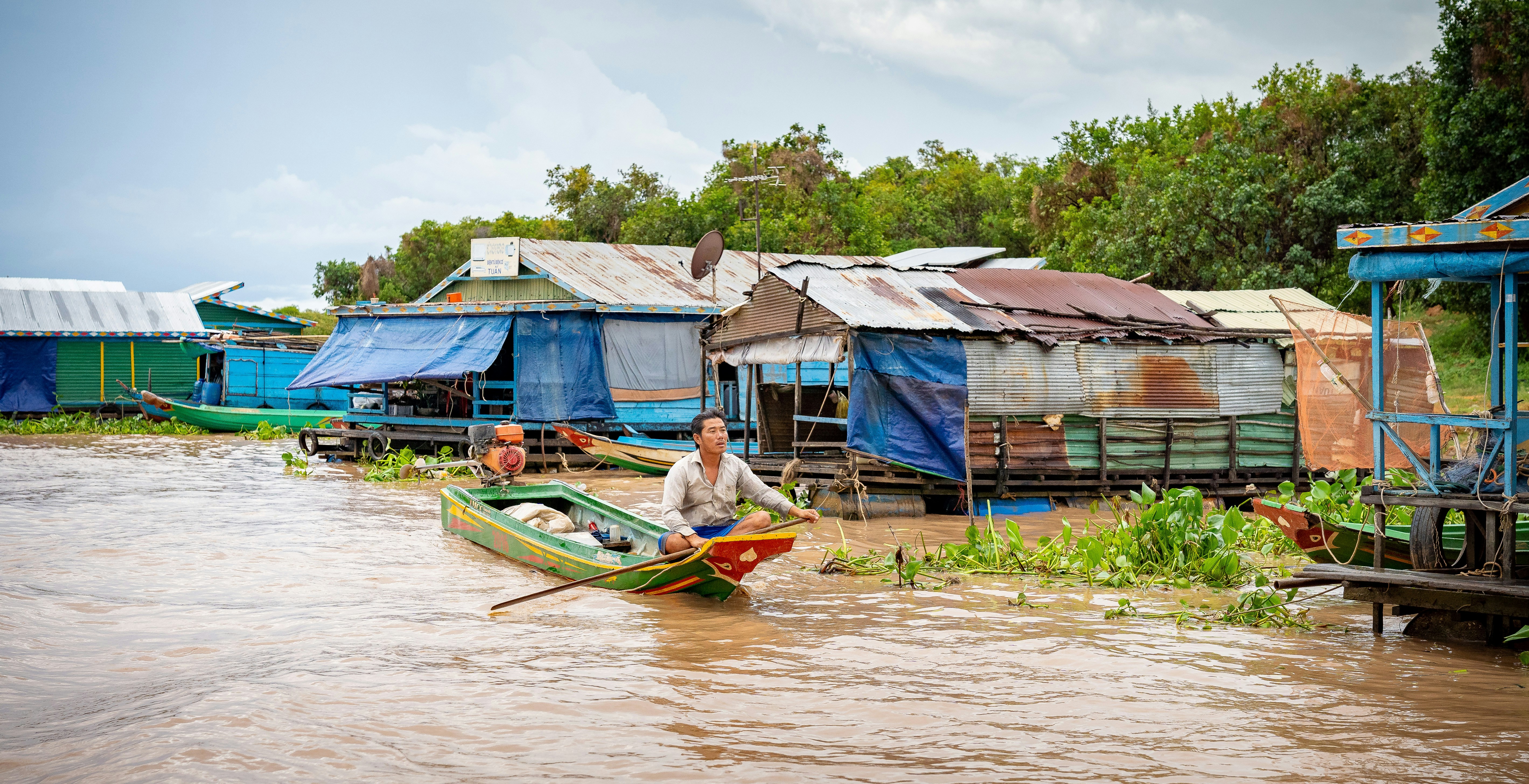 Man riding boat near stilt houses photo – Free Nature Image on Unsplash