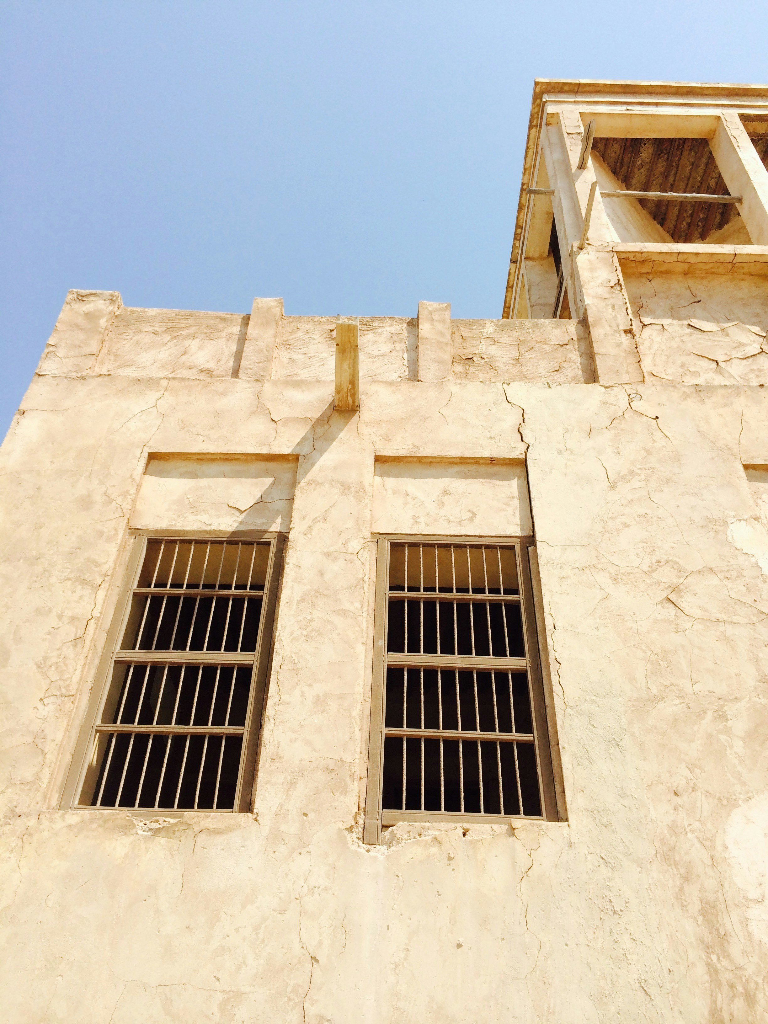 Sun-bleached Facade: Windows and Sky Above an Old Building
