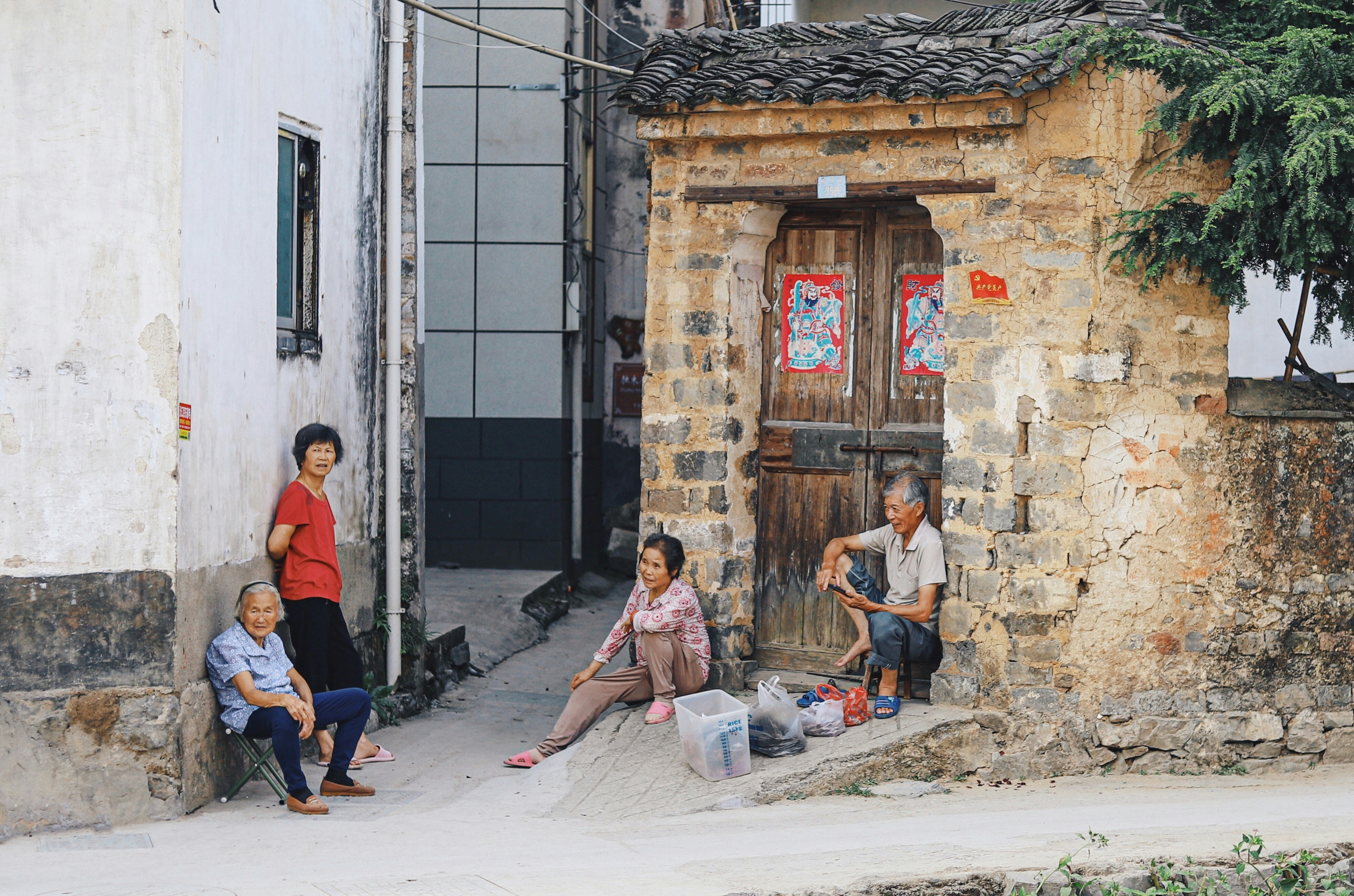 Four people talking outside house photo – Free Person Image on Unsplash