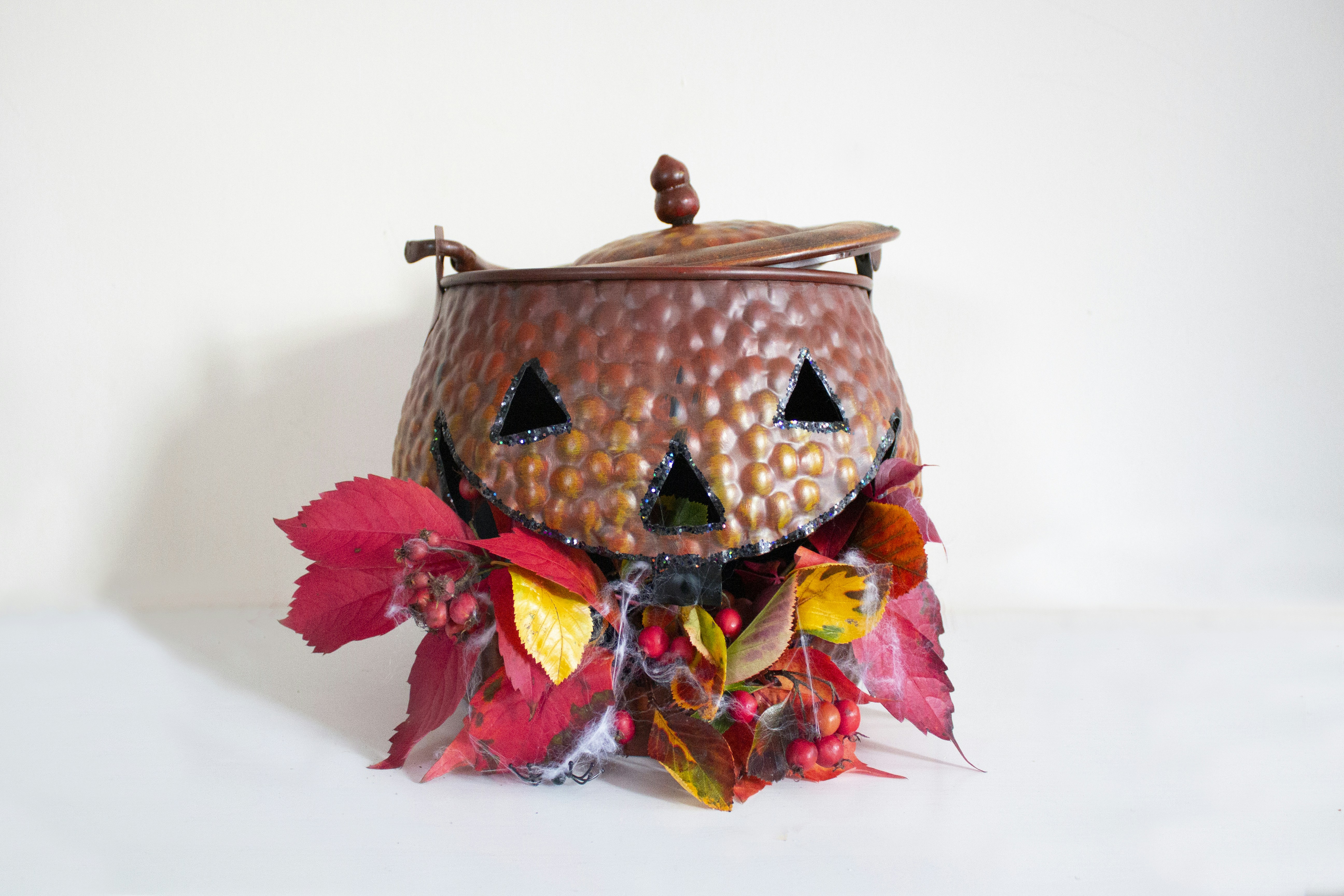 Glazed Pumpkin Lantern Nestled Among Crimson Autumn Leaves