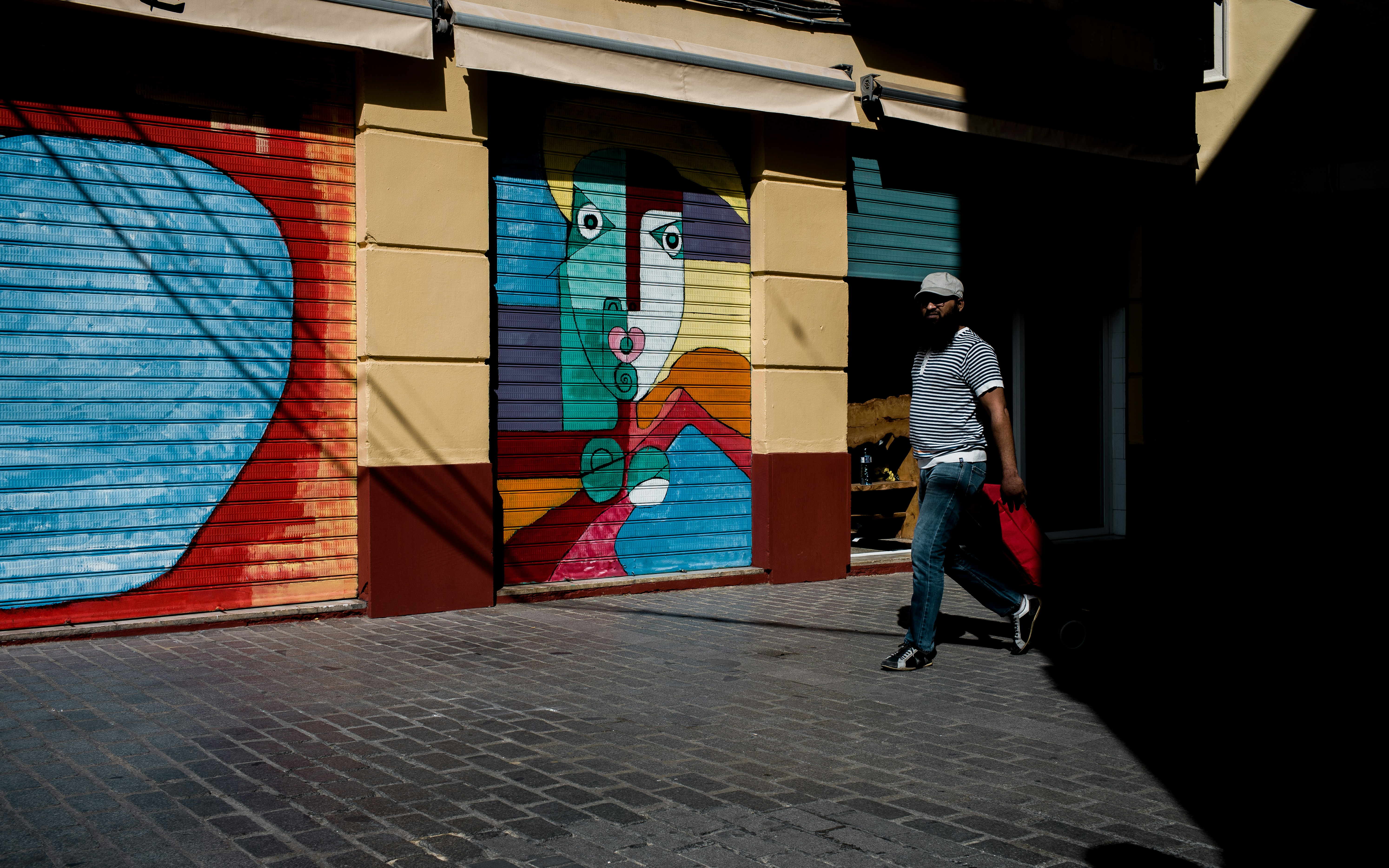 man walking beside graffiti wall