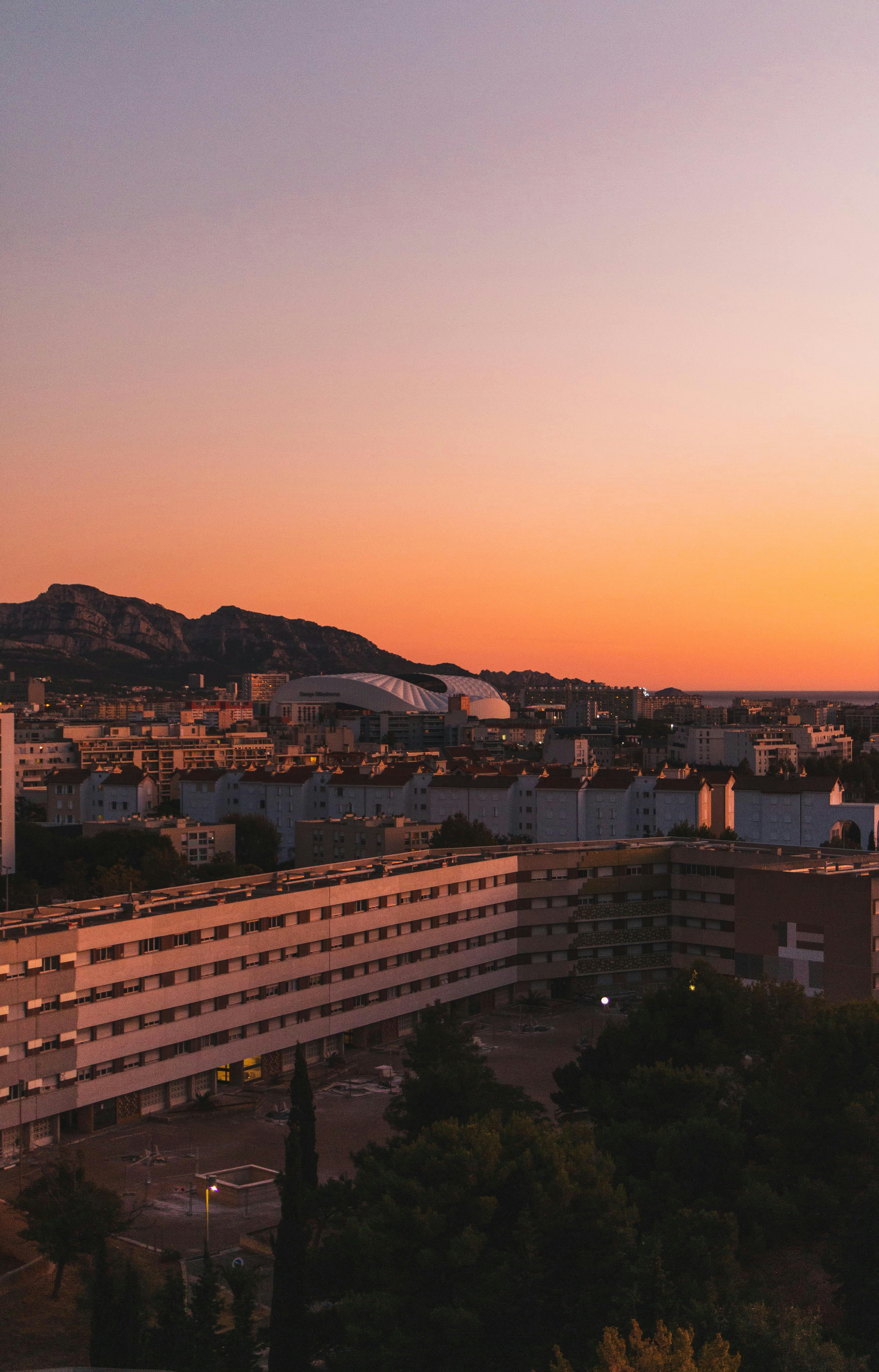 Sunset Over the City: Distant Stadium and Rooftops