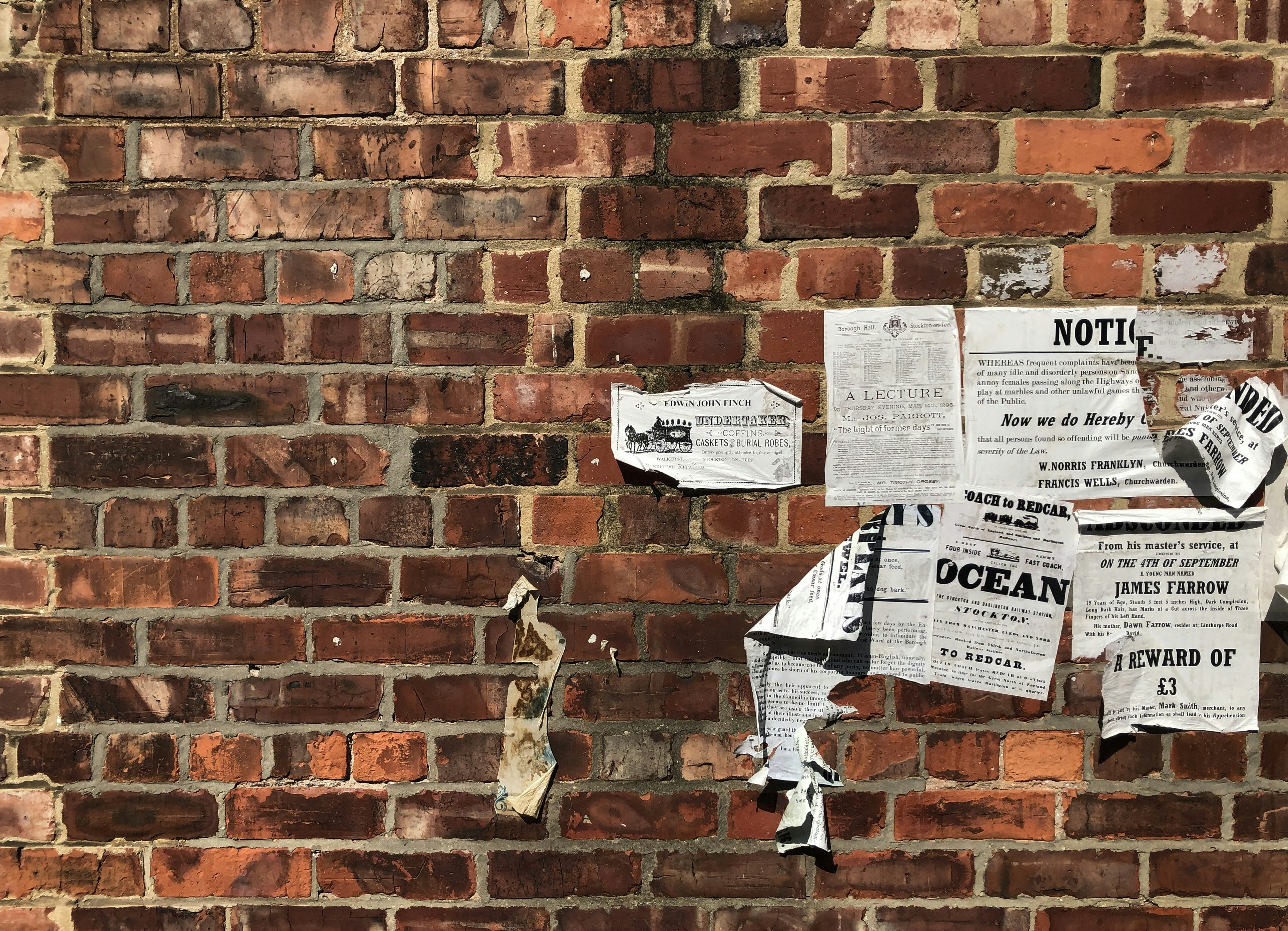 A brick wall with a bunch of torn newspaper on it photo – Free Brick ...
