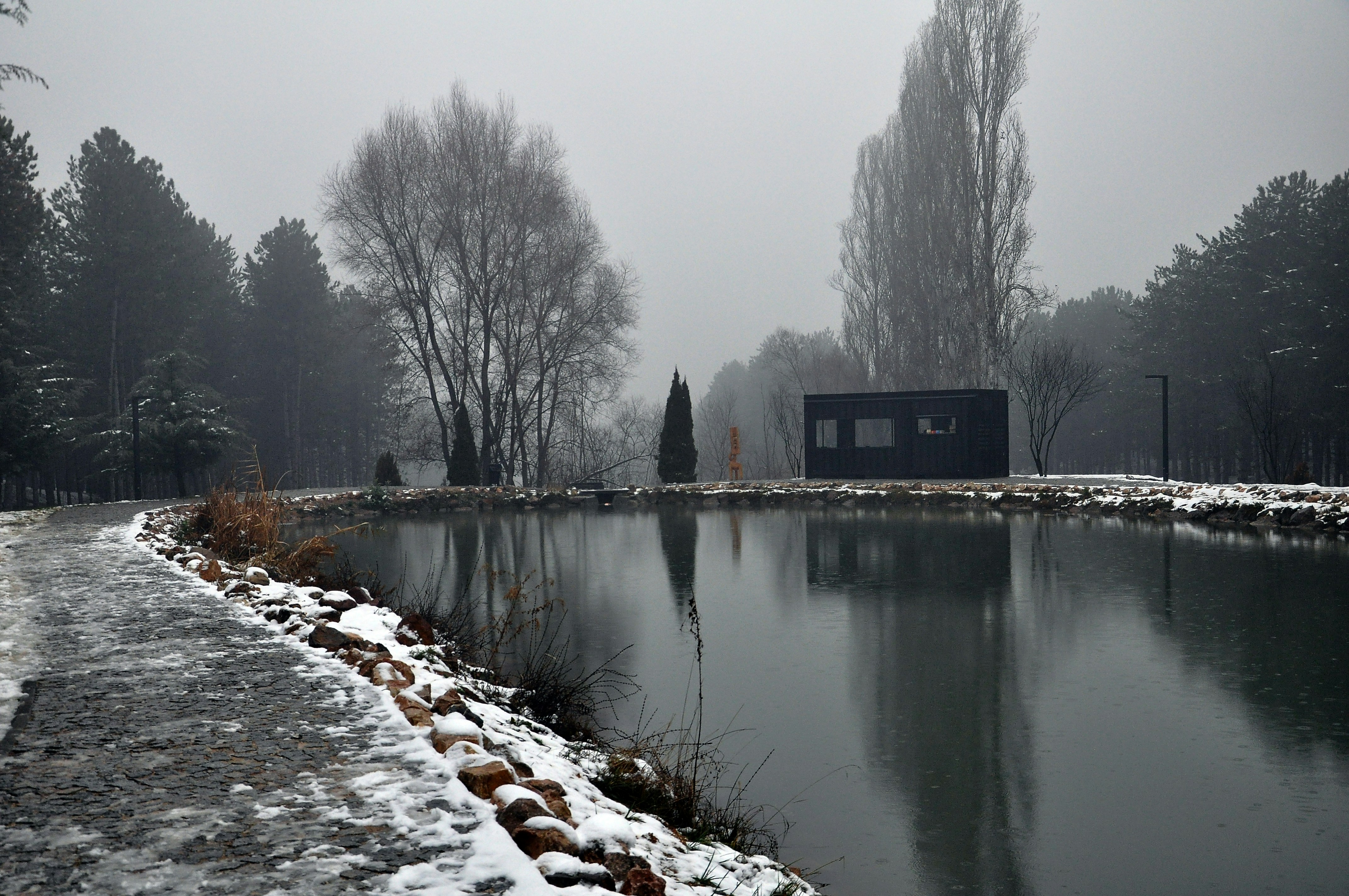 Winter Quiet by the Black Pavilion: Reflections Across a Snow-Dusted Pond