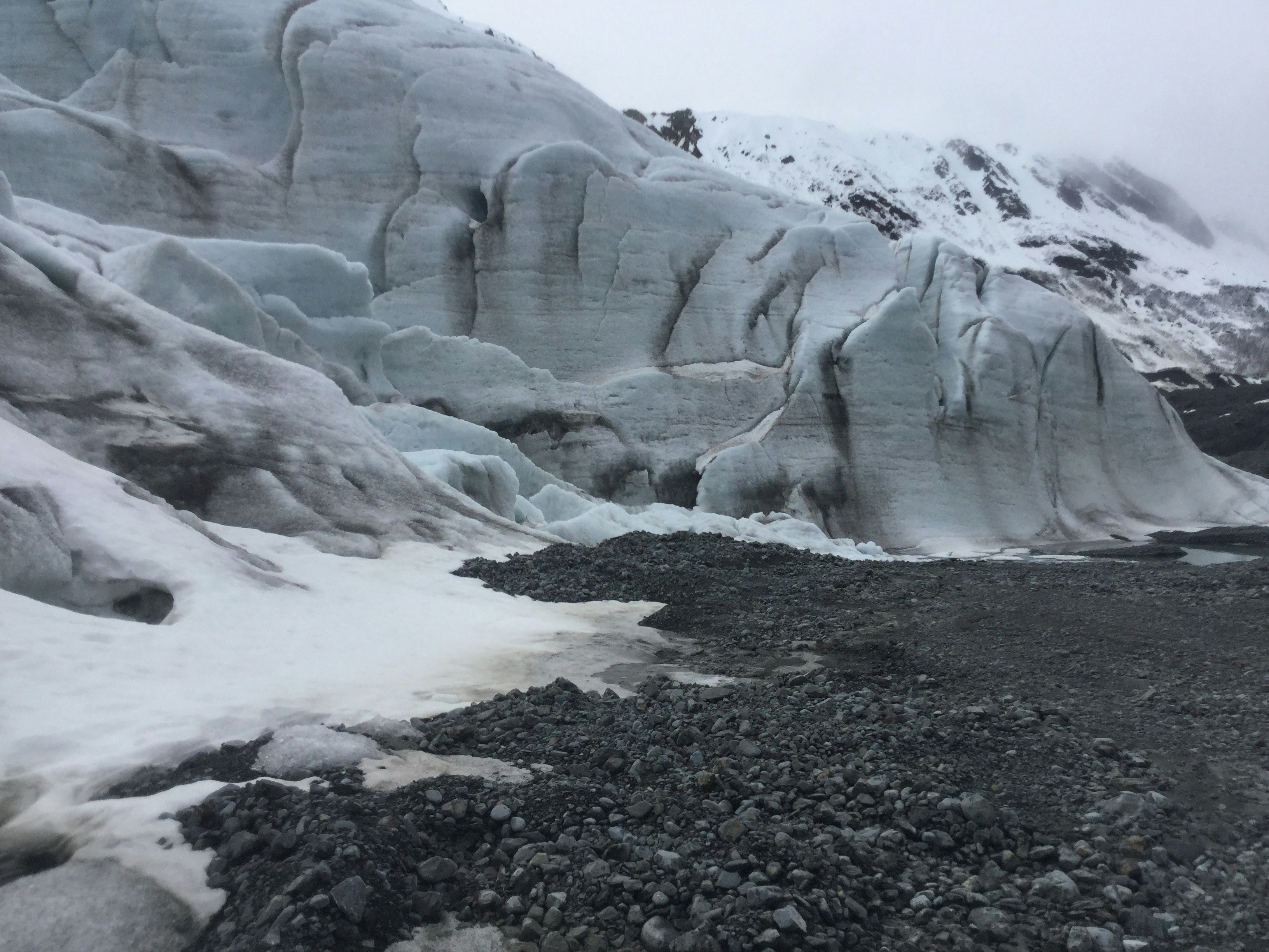 Massive glacial formations reveal intricate textures and colors against a rocky foreground, capturing the essence of a frozen landscape.