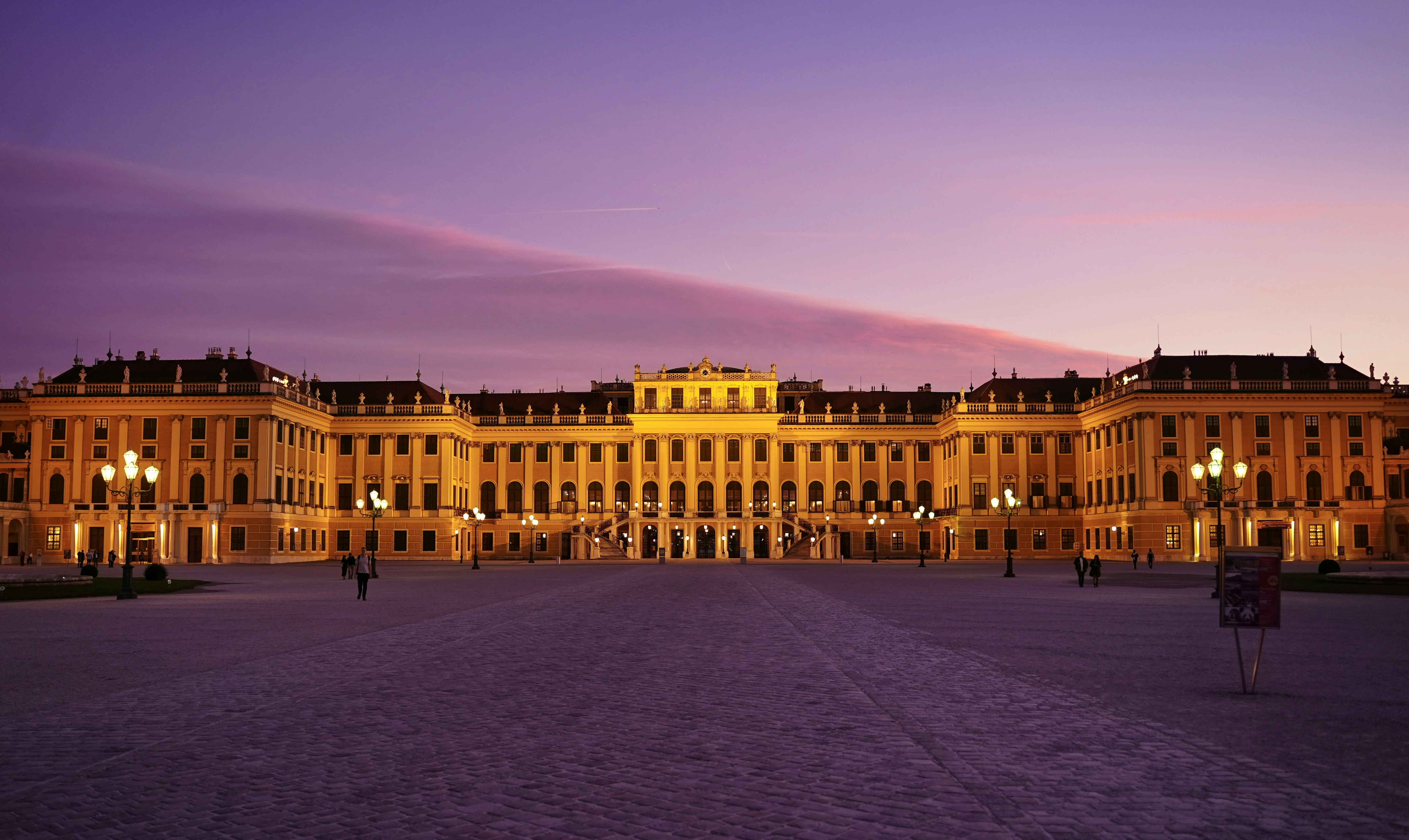 Ornate palace facade brilliantly lit against a purple twilight sky.