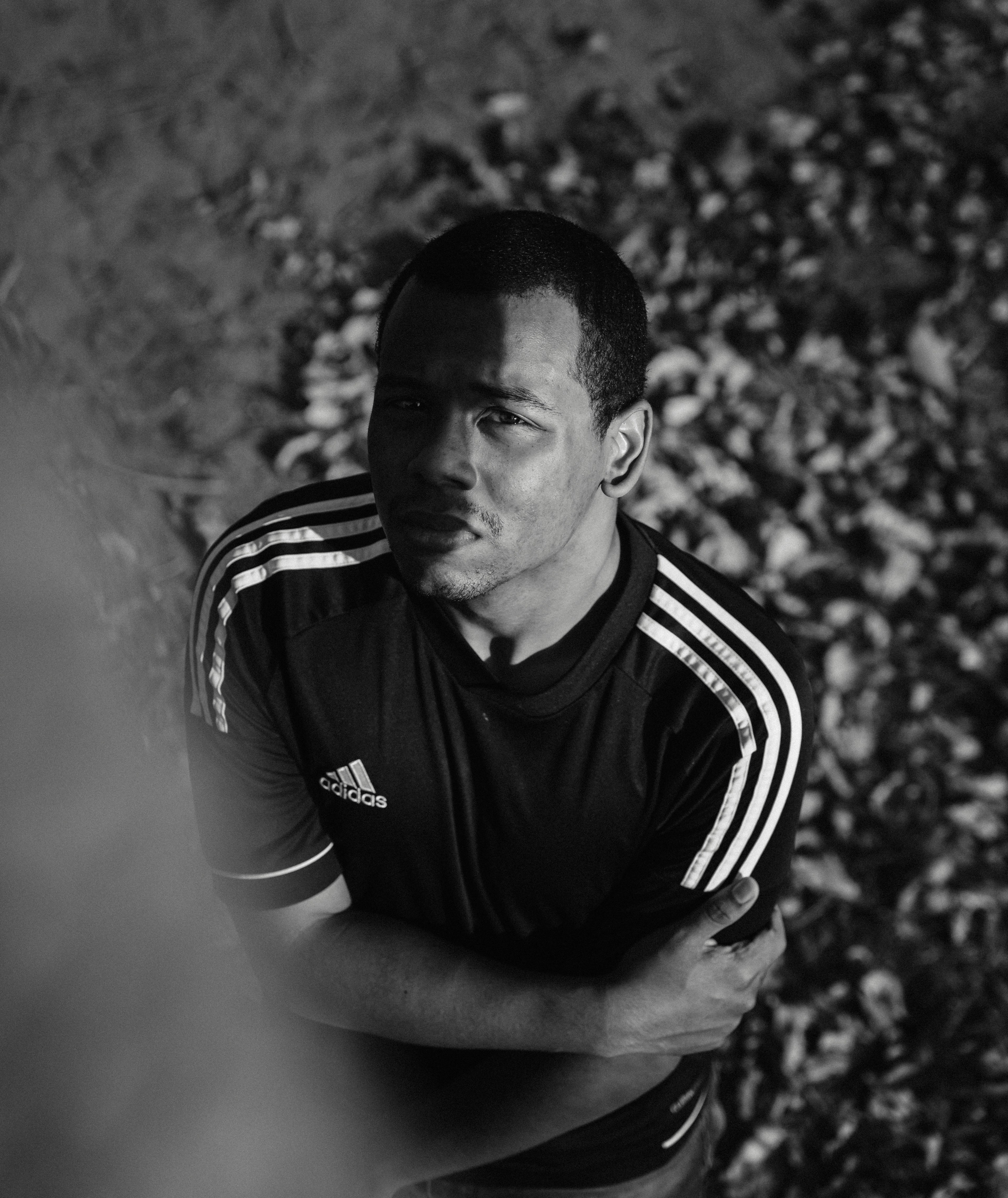 Shade and Gaze: A Quiet Black-and-White Portrait Under Leaves