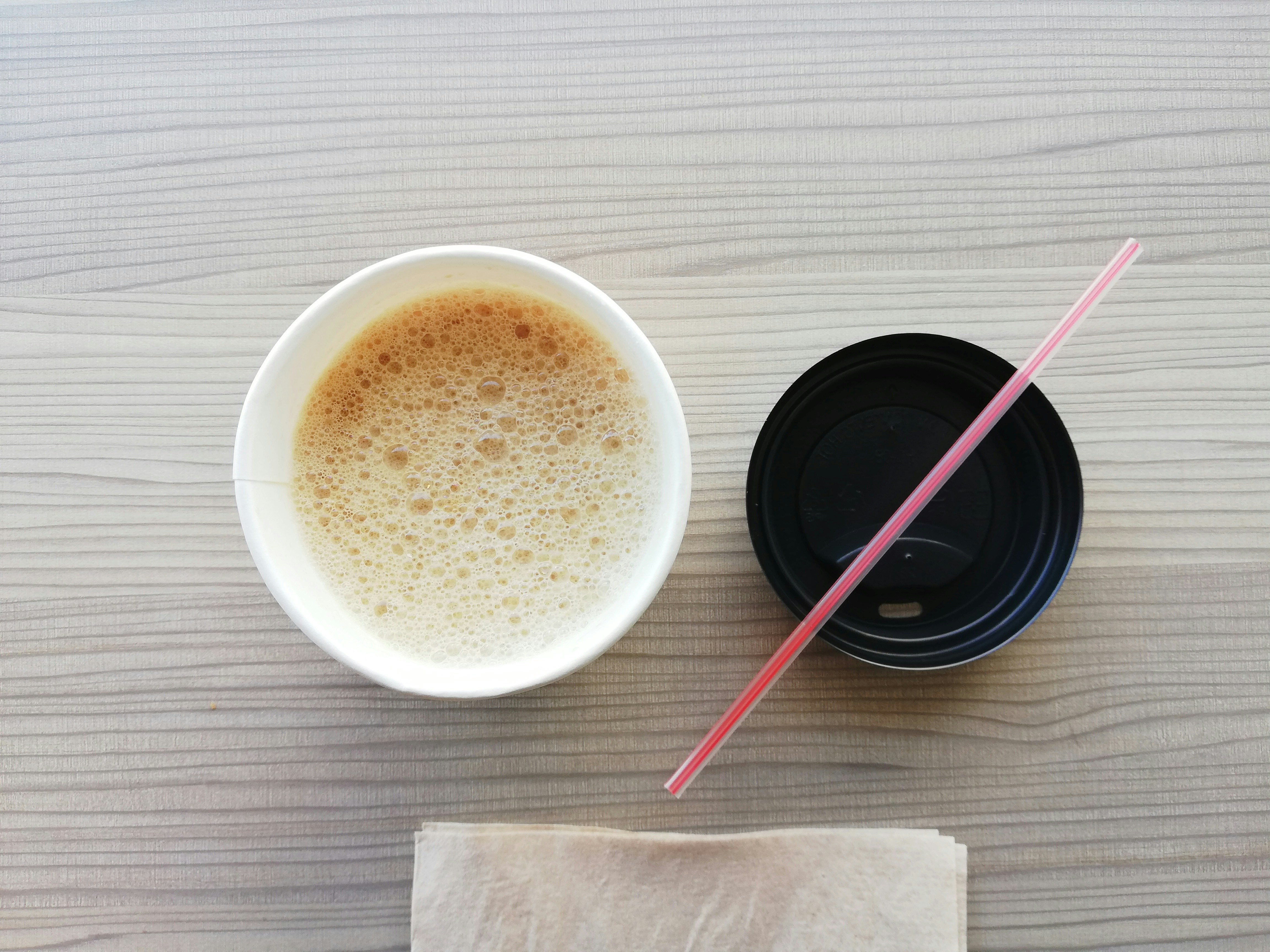 Top‑Down Sip: Coffee Cup and Lidded Dripper on a Light Wood Table