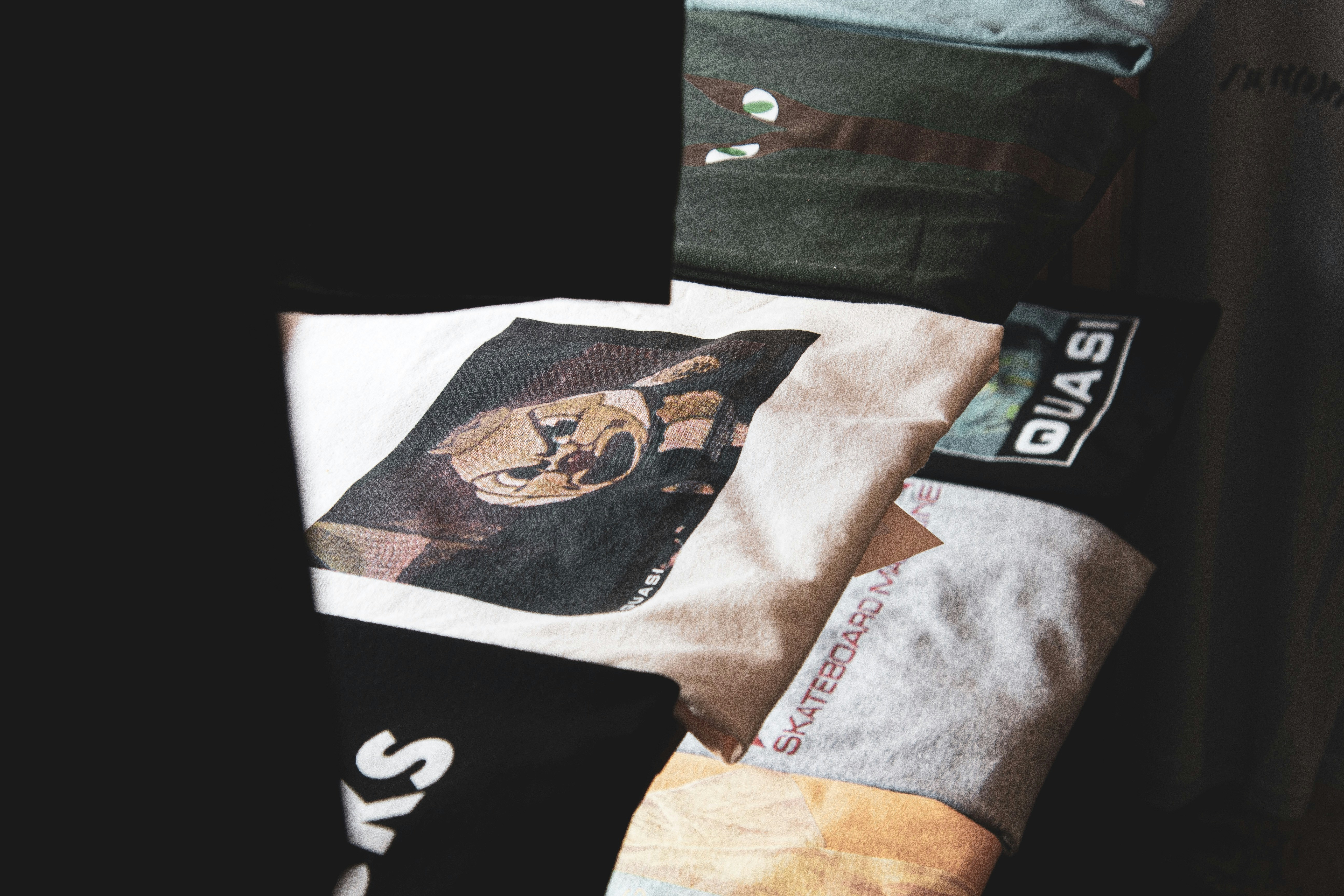 a pile of shirts sitting on top of a bed