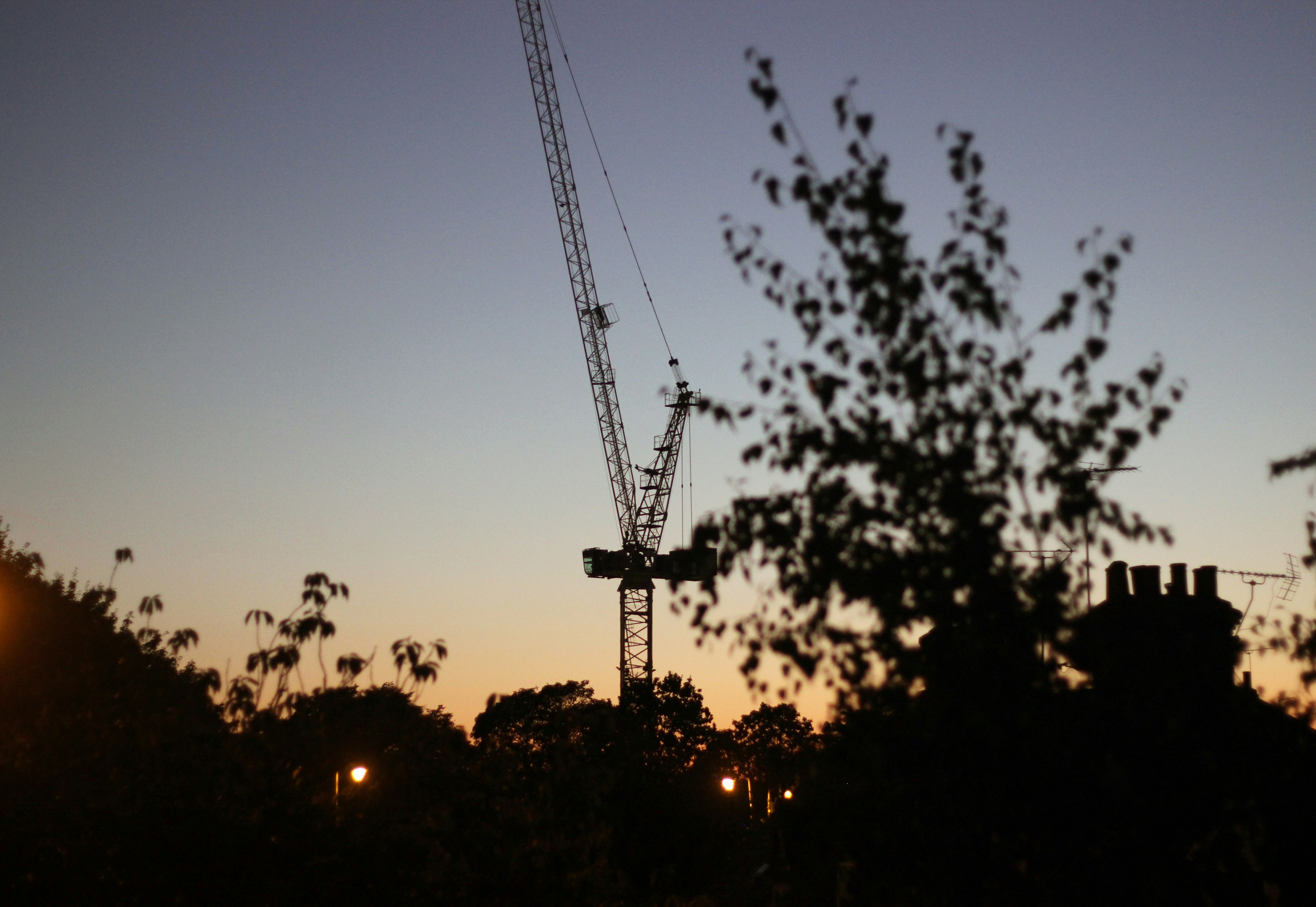Twilight Crane: silhouette of a lone tower against the sunset skyline