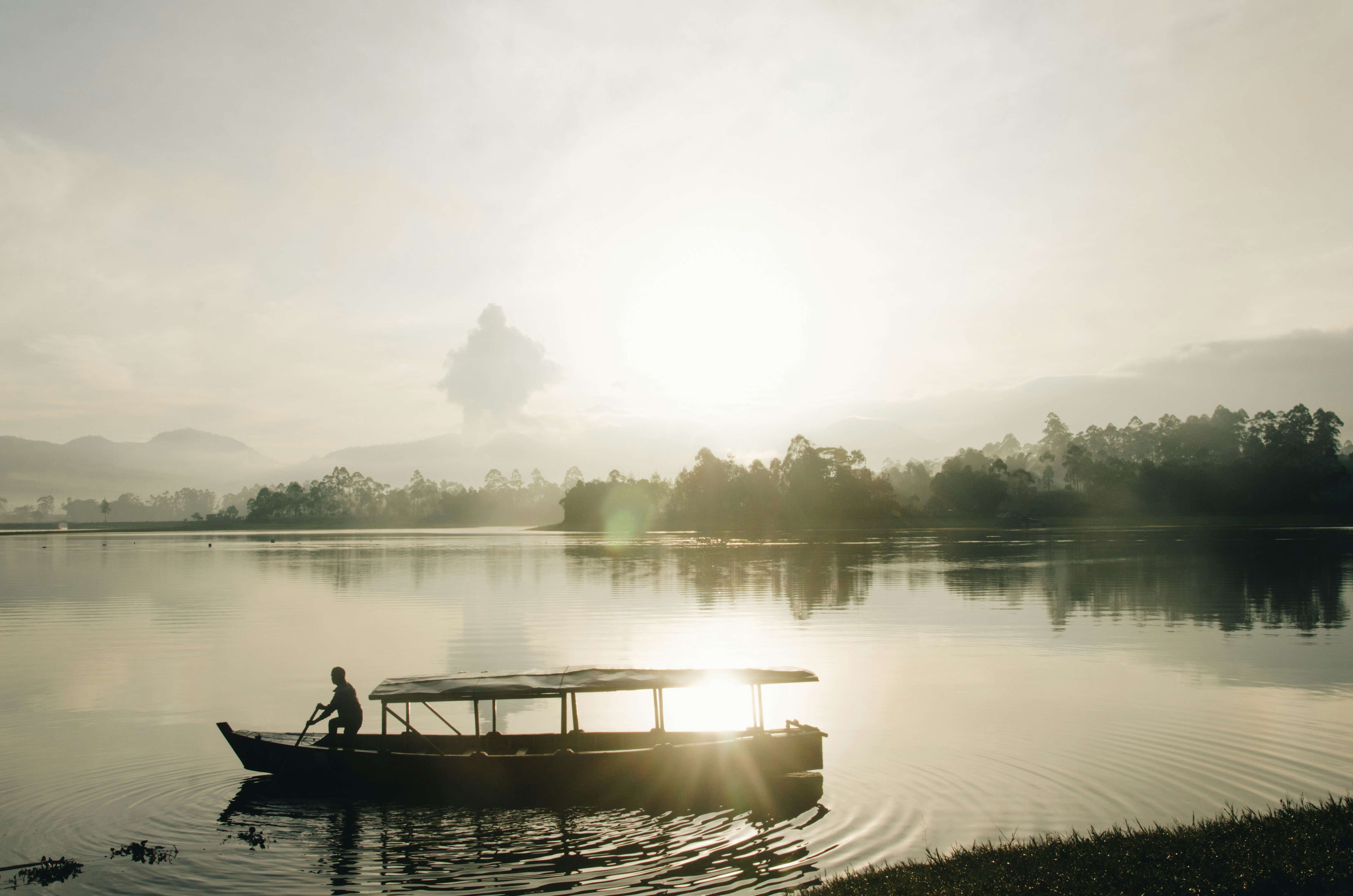 Dawn on the Quiet River: A Lone Rowboat Silhouette Brushed by Mist