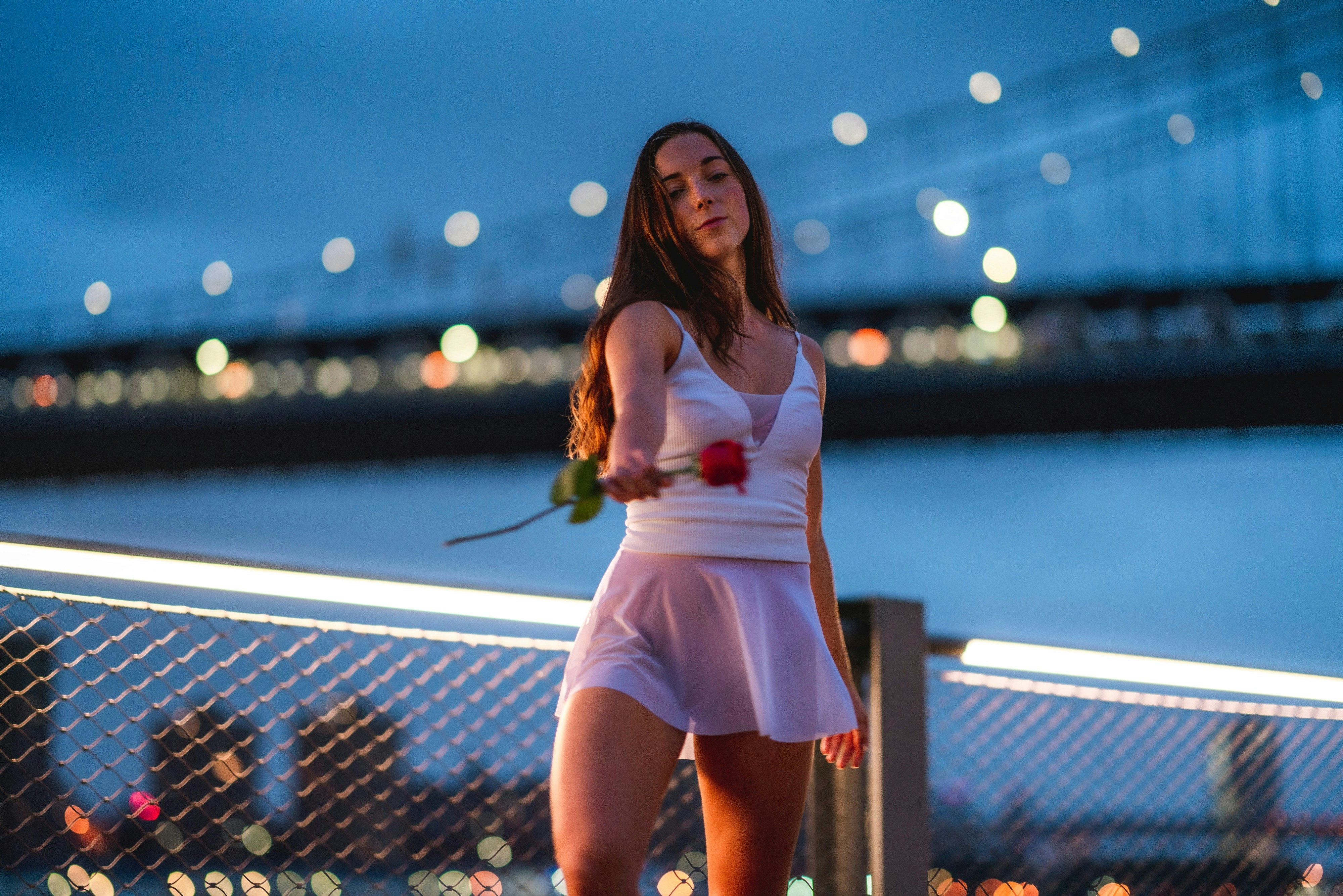 Rose on the Riverfront: A Nightfall Portrait by the Bridge