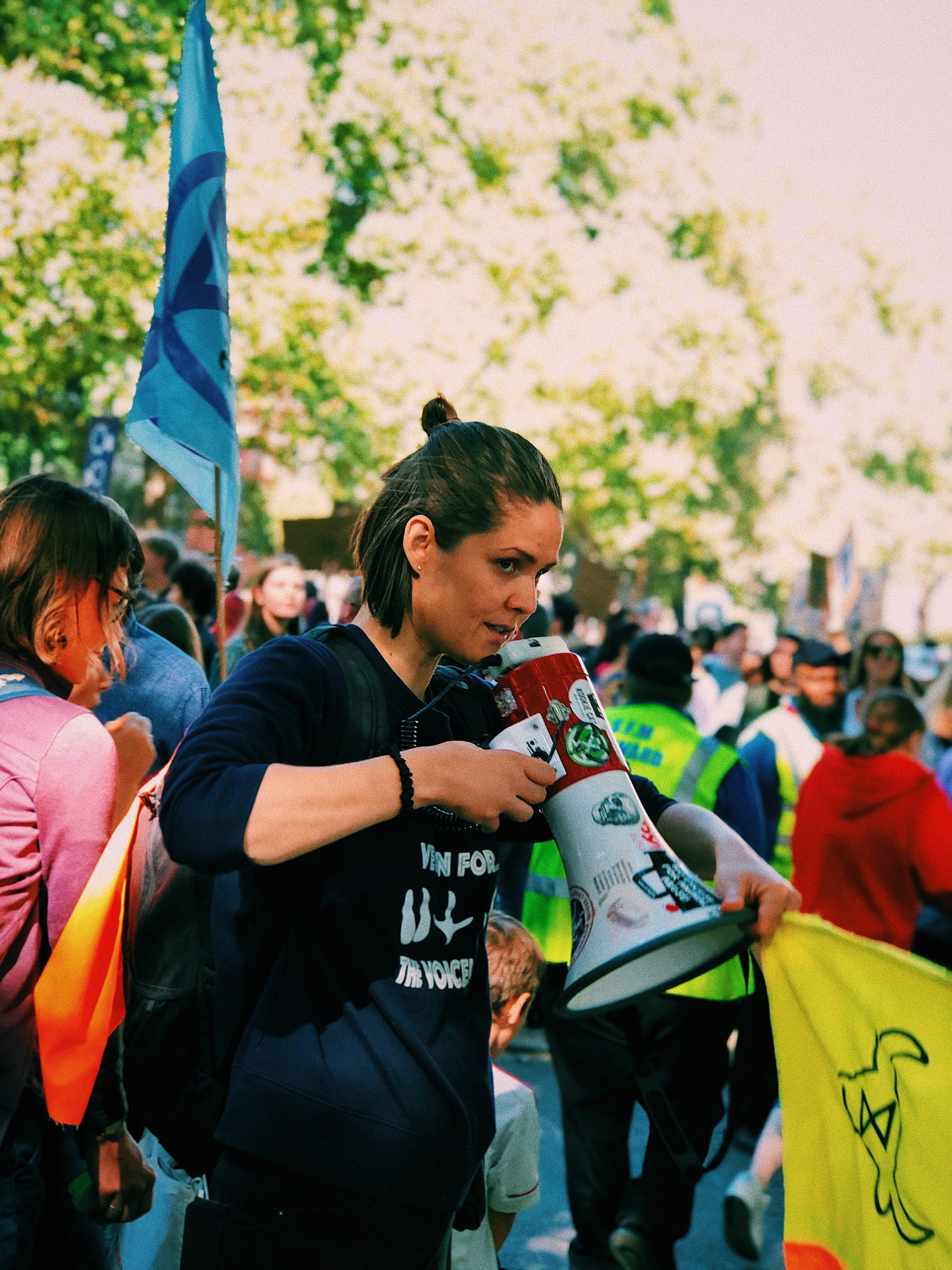 Activist passionately speaking into a megaphone amidst a crowd at a demonstration, showcasing the spirit of civic engagement.