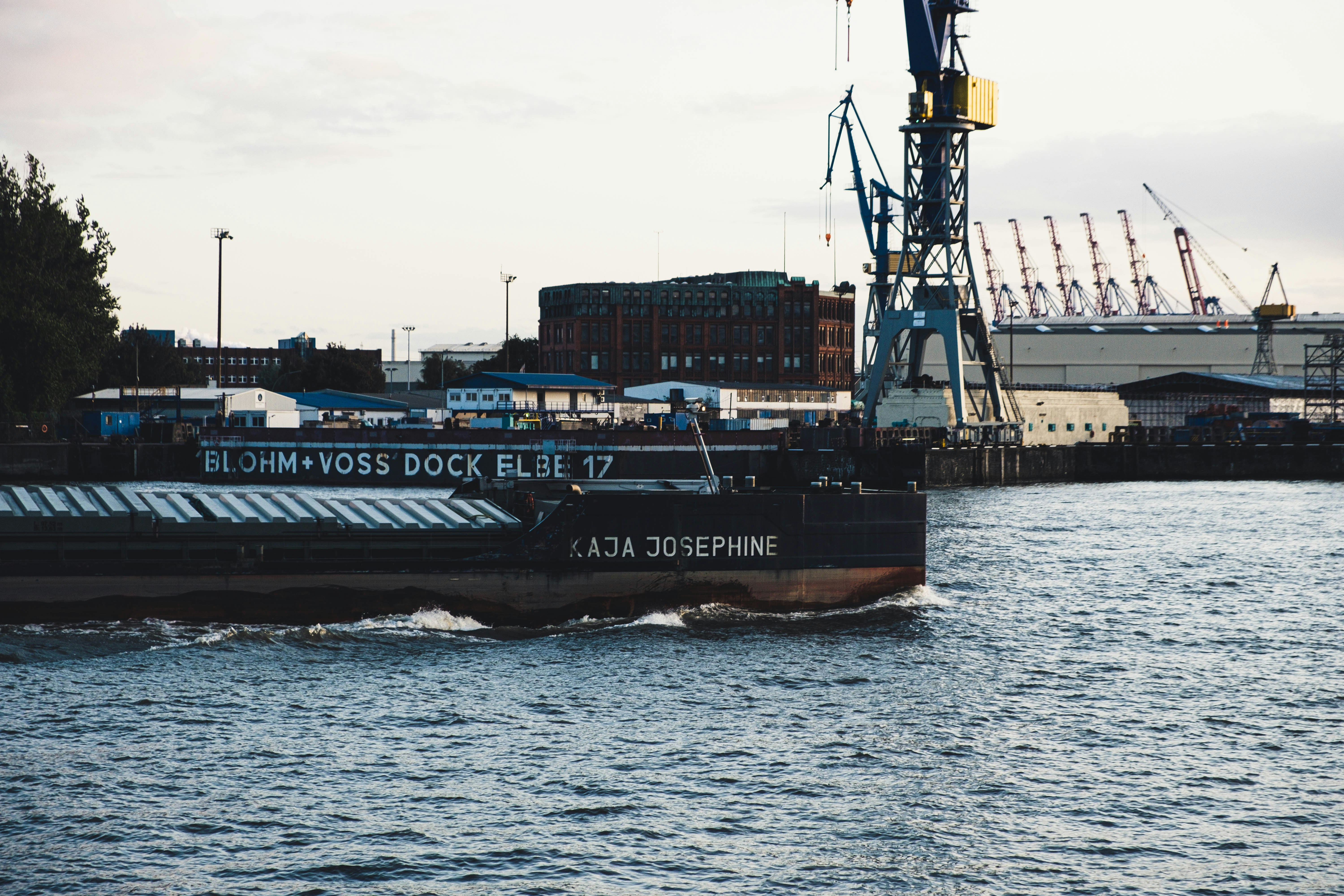 Kaja Josephine at Elbe Dock: Cargo Barge Gliding Past Blohm+Voss Cranes