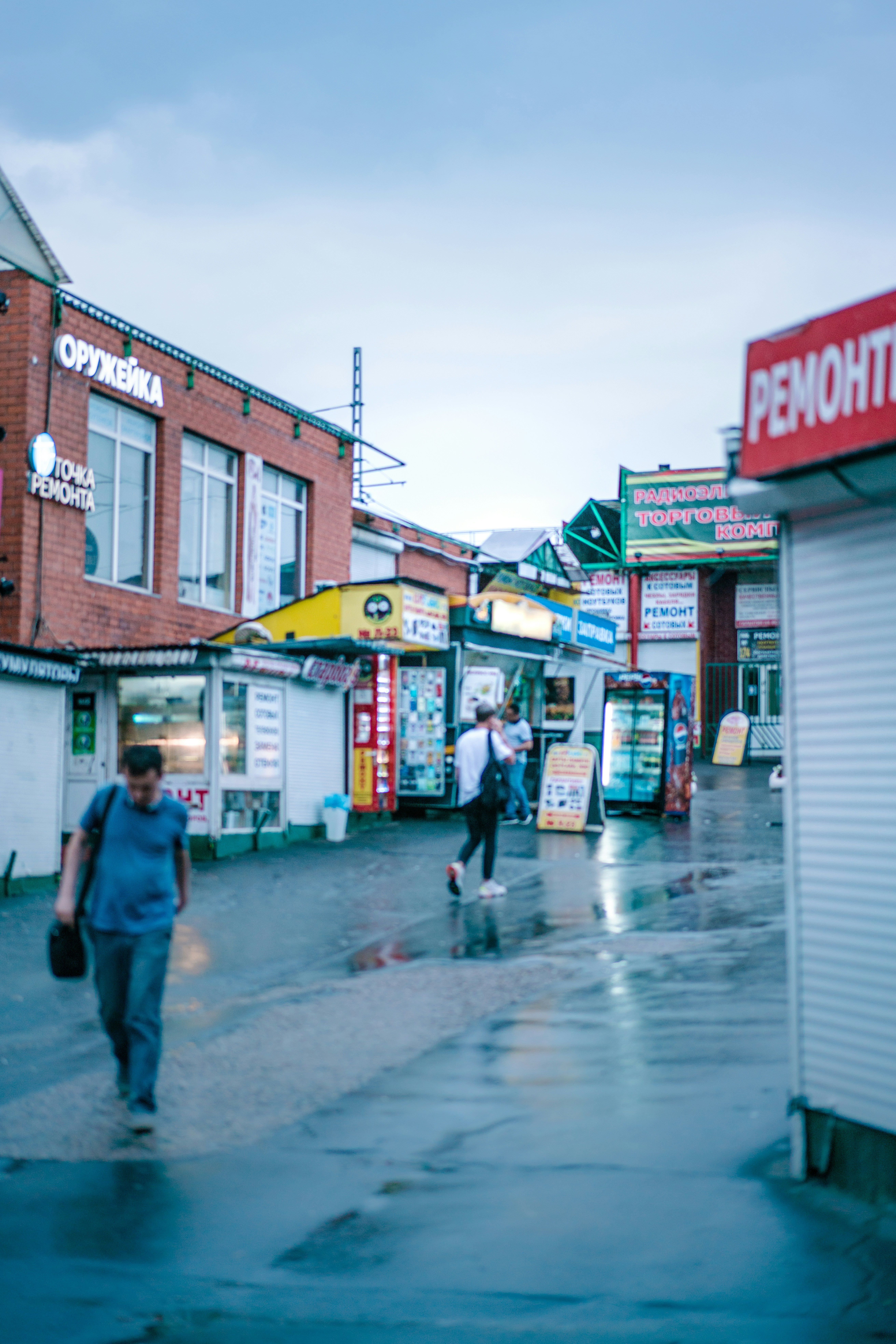 Market Corridor in Soft Rain Under Neon Signs