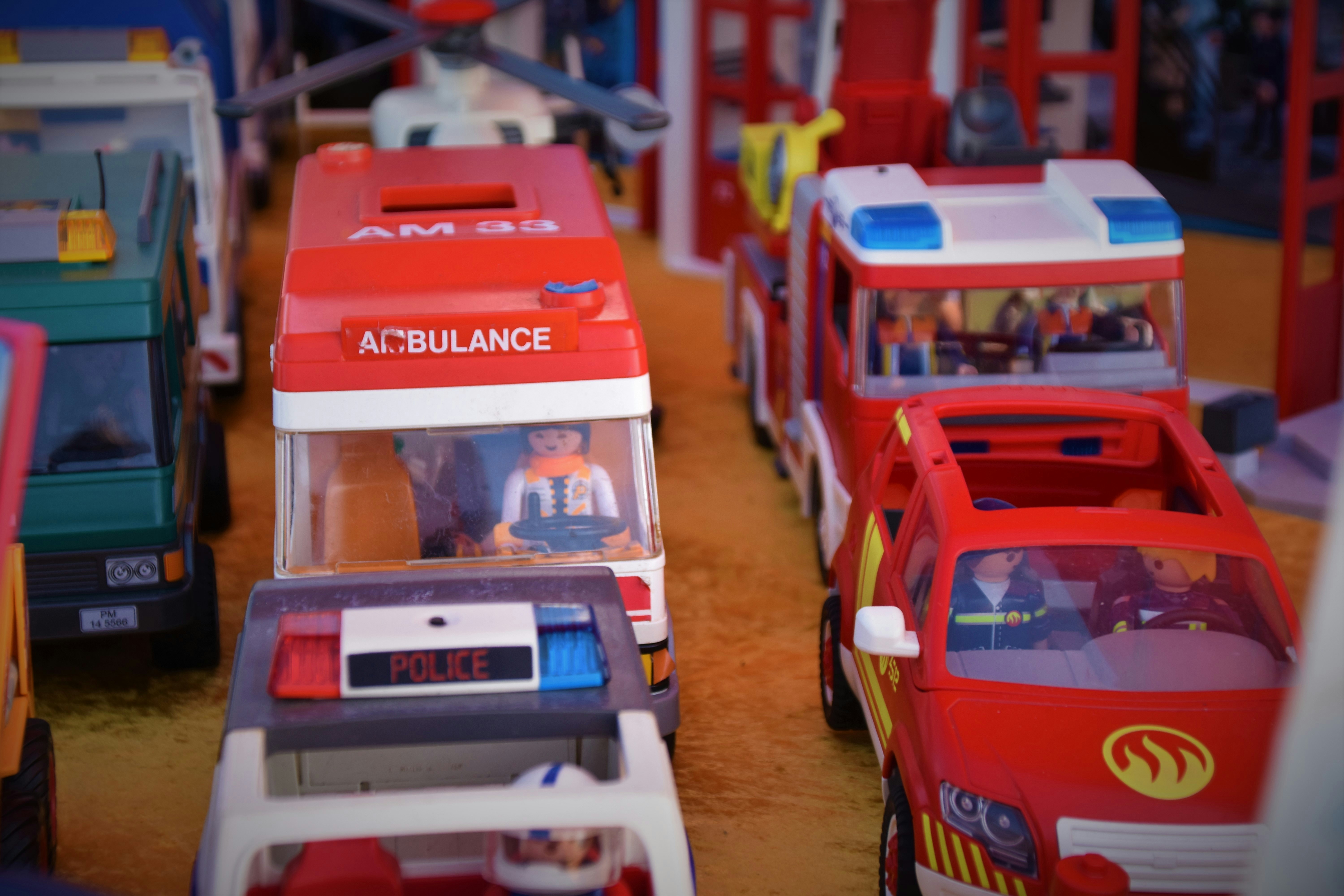 Miniature Sirens Row: A Close-Up of Toy Emergency Vehicles in a Bright Playset