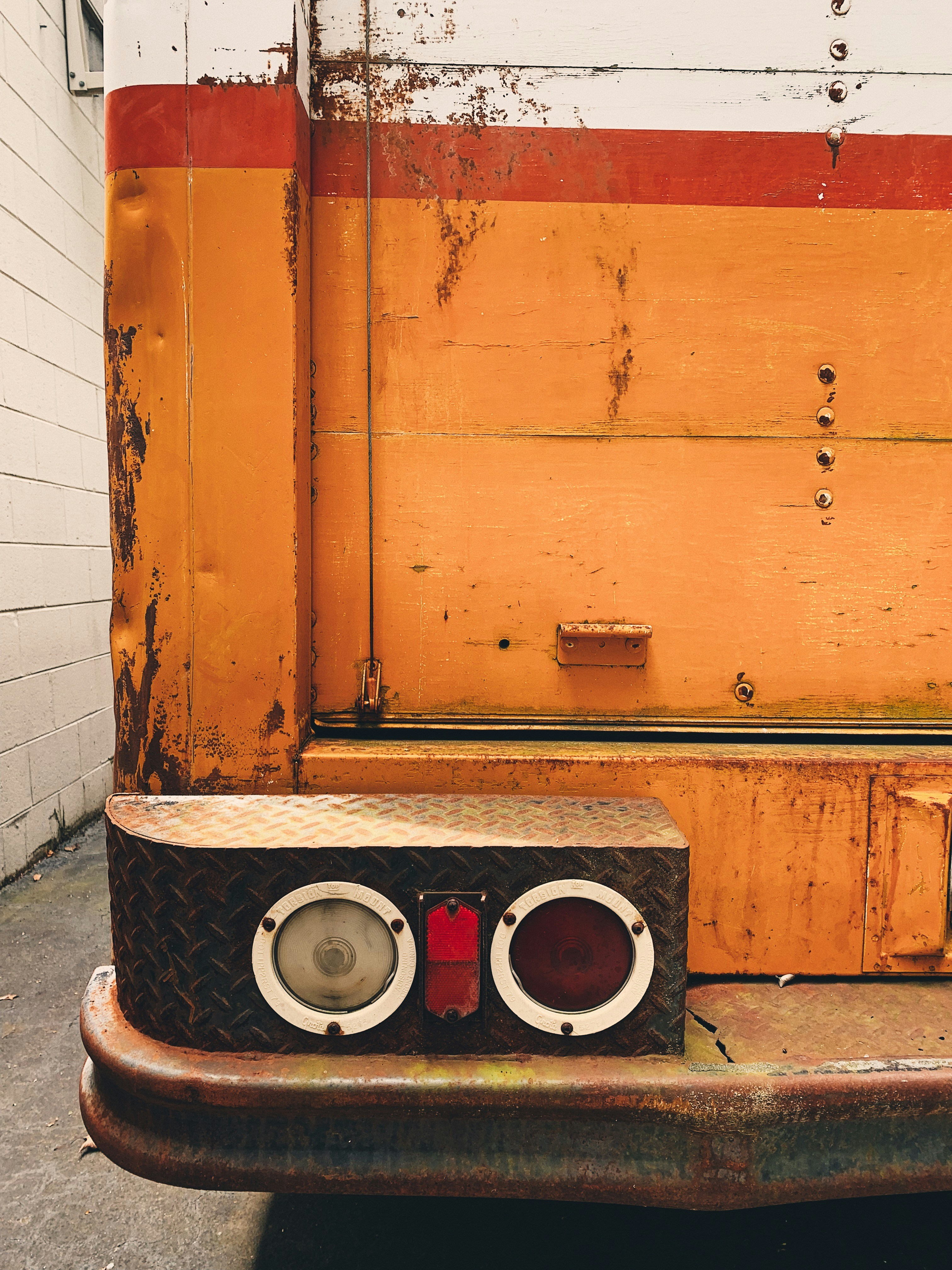 Rusty orange tailgate with circular lights and diamond-plate housing
