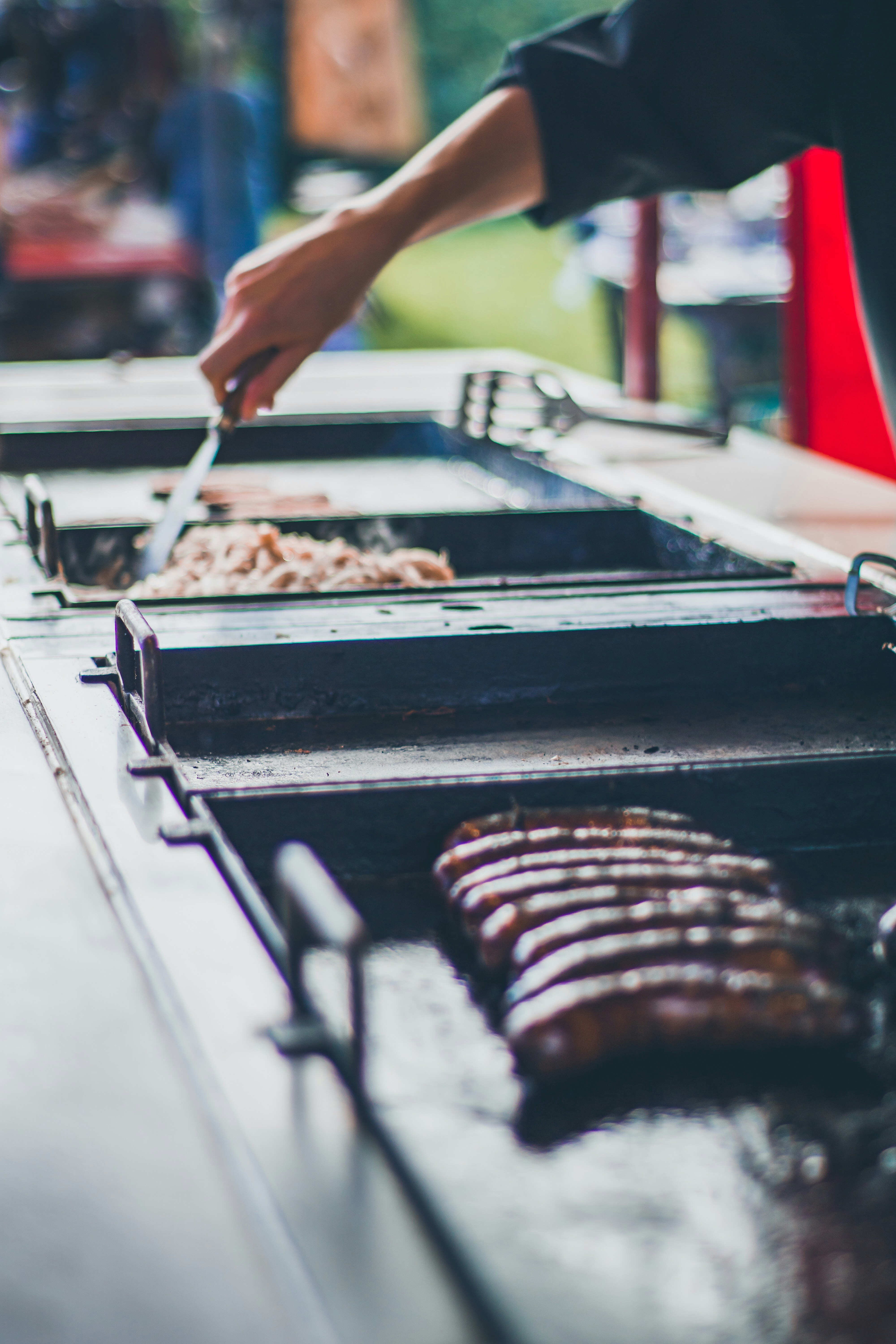 Flame-Hand Over a Street Grill: Tongs in Motion