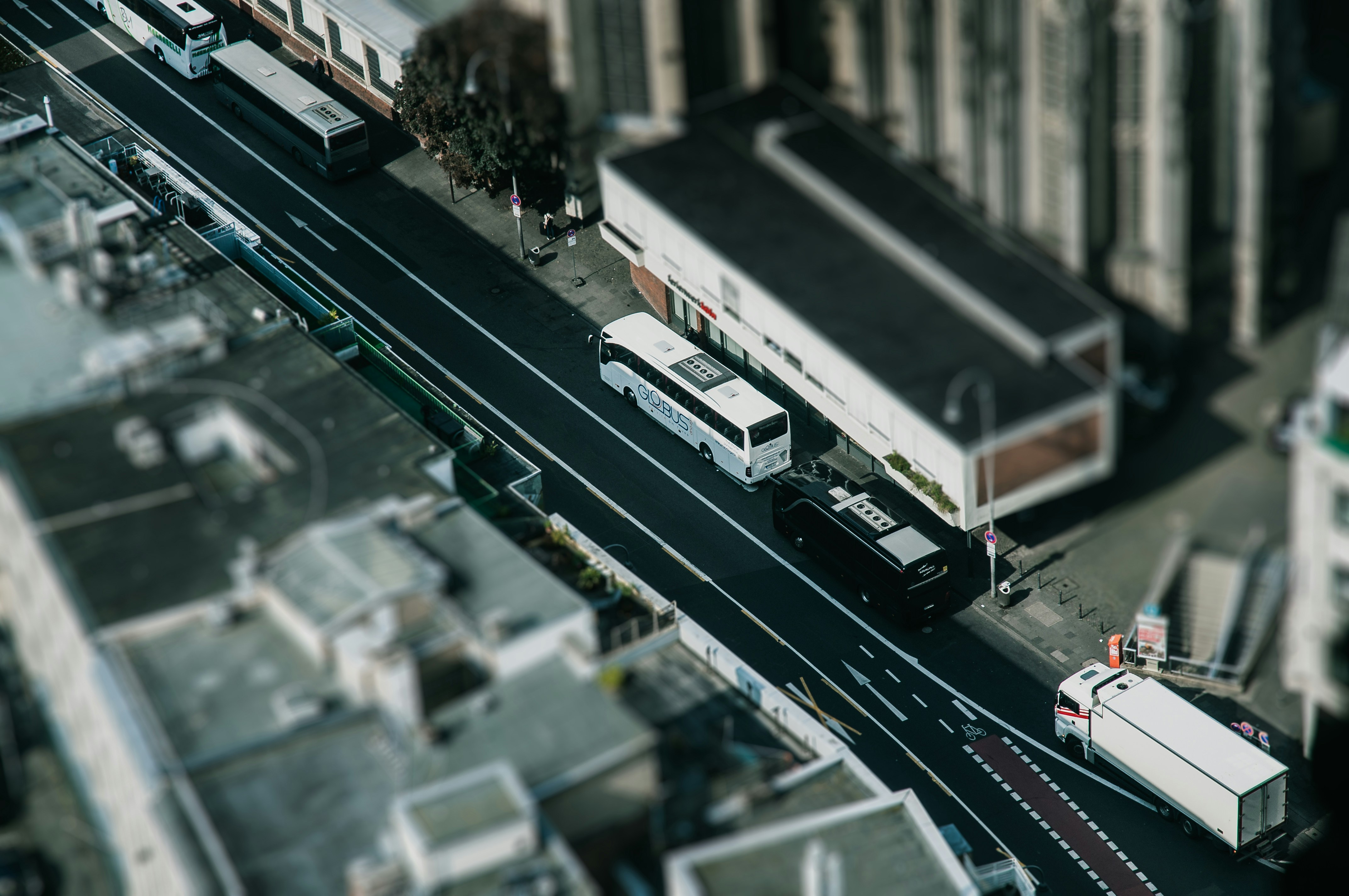 Tilt-Shift Transit: A Miniature City Street Framed by Buses and Buildings