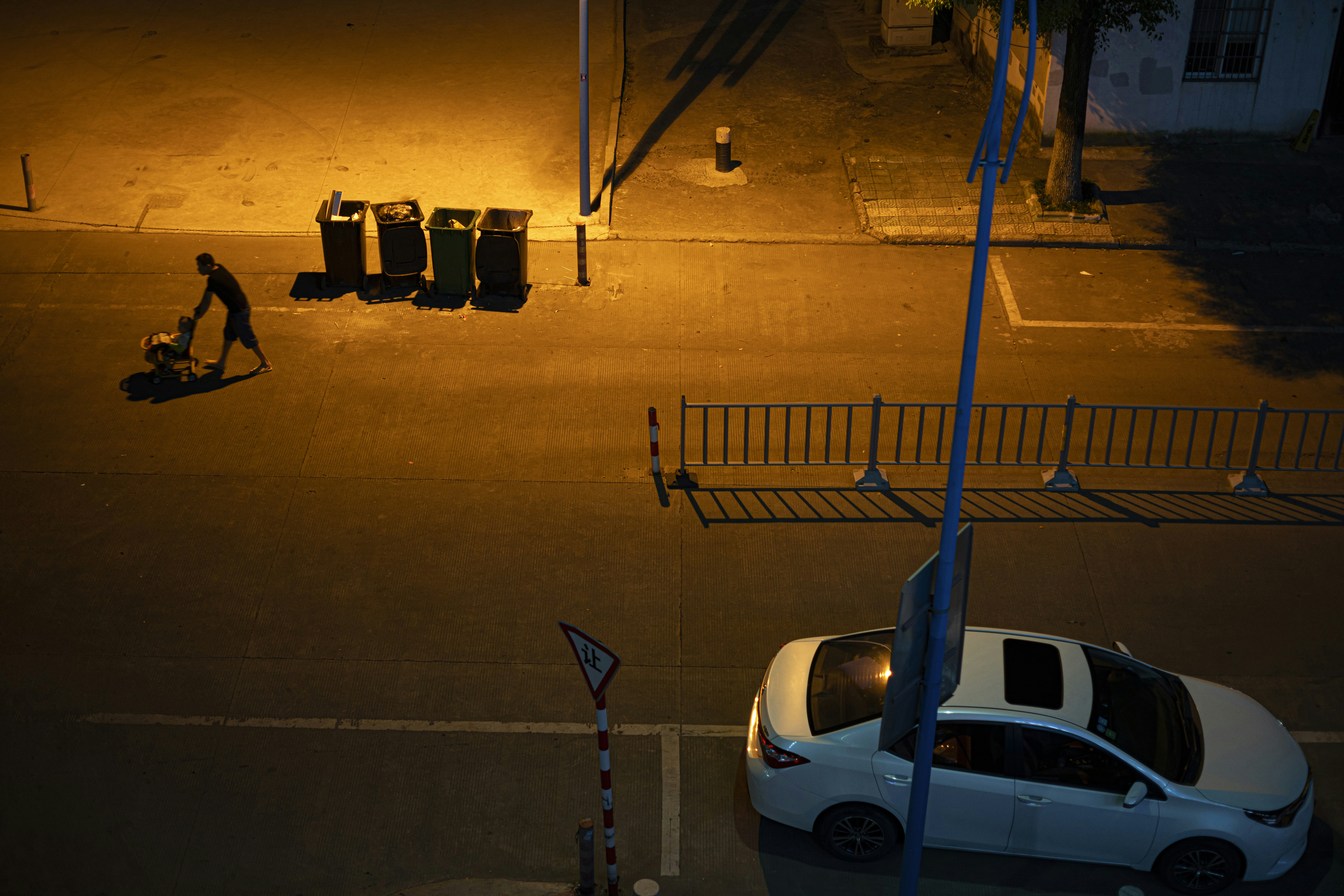 Quiet Street at Night: A Lone Pedestrian and Parked Car