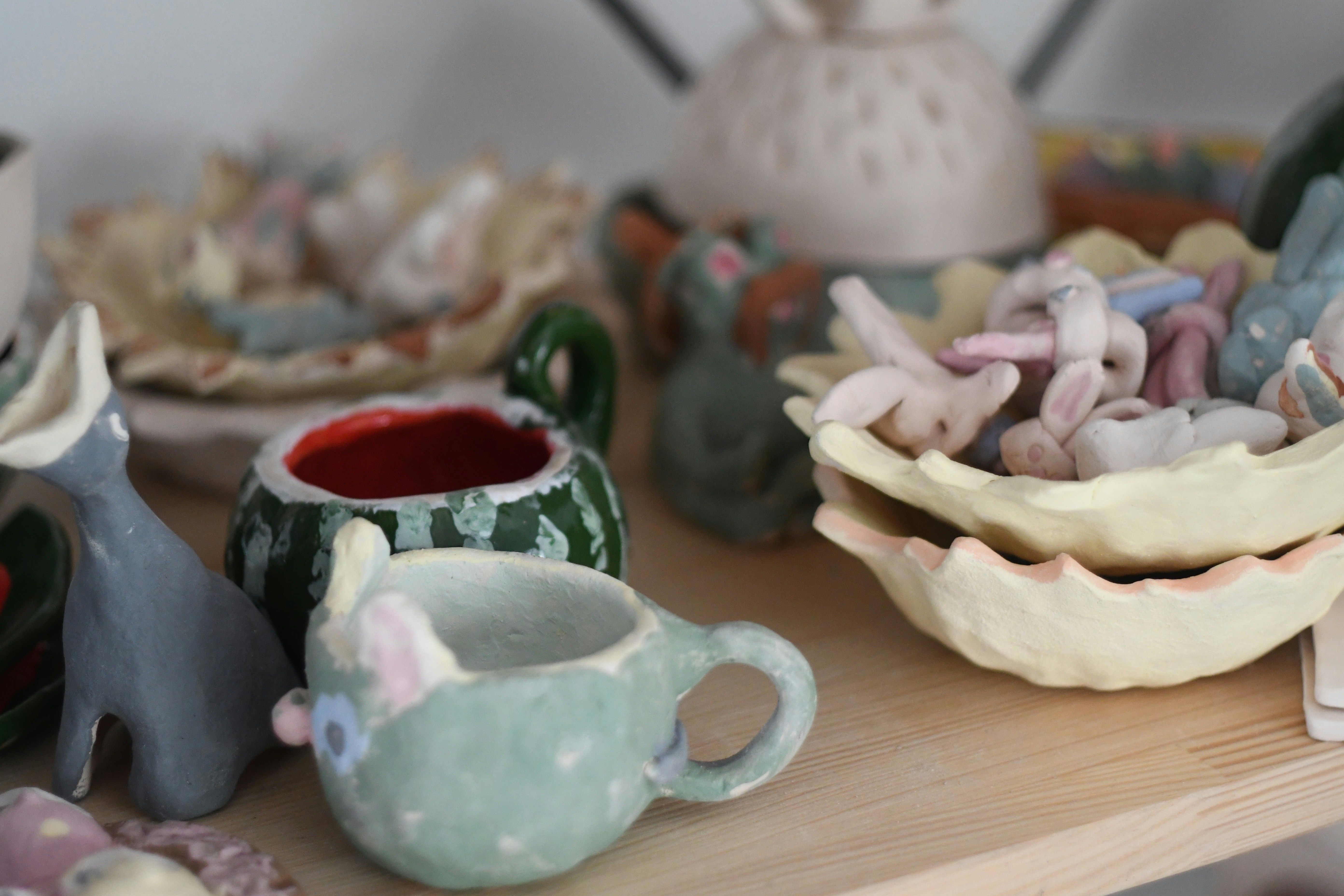 Pastel Glazed Medley: Handmade Ceramics on a Wooden Shelf
