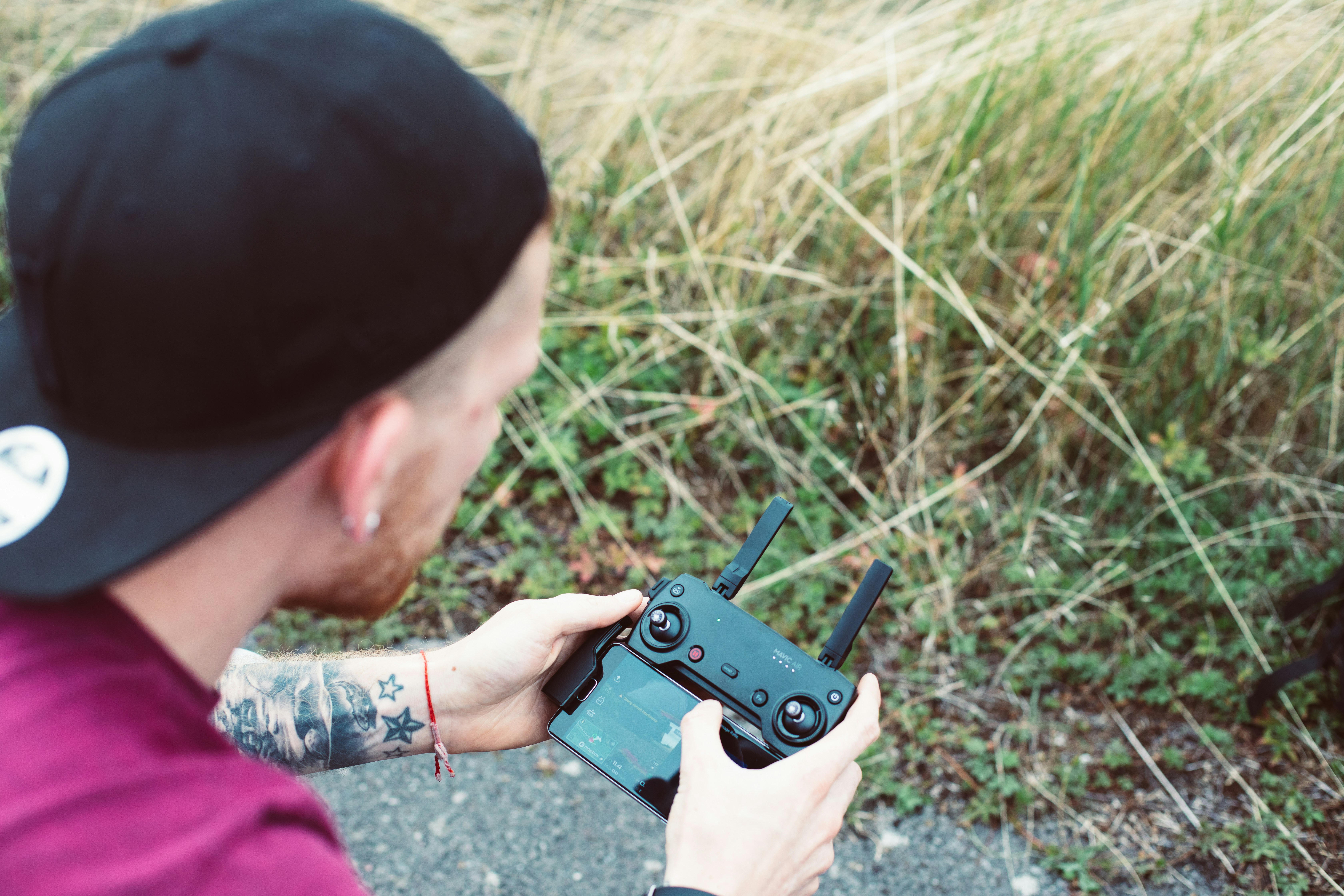 Operator in profile guiding a compact transmitter through grassy terrain