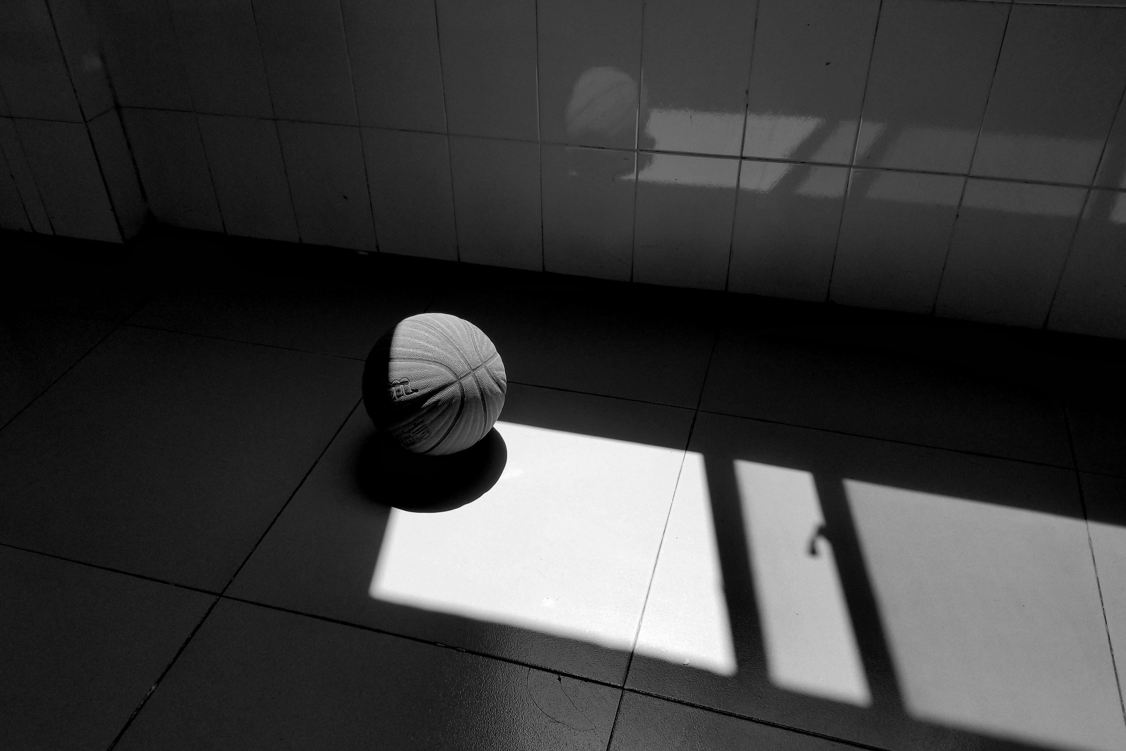 Single Ball, Striped Shadow: Minimal Light in a Quiet Tile Room