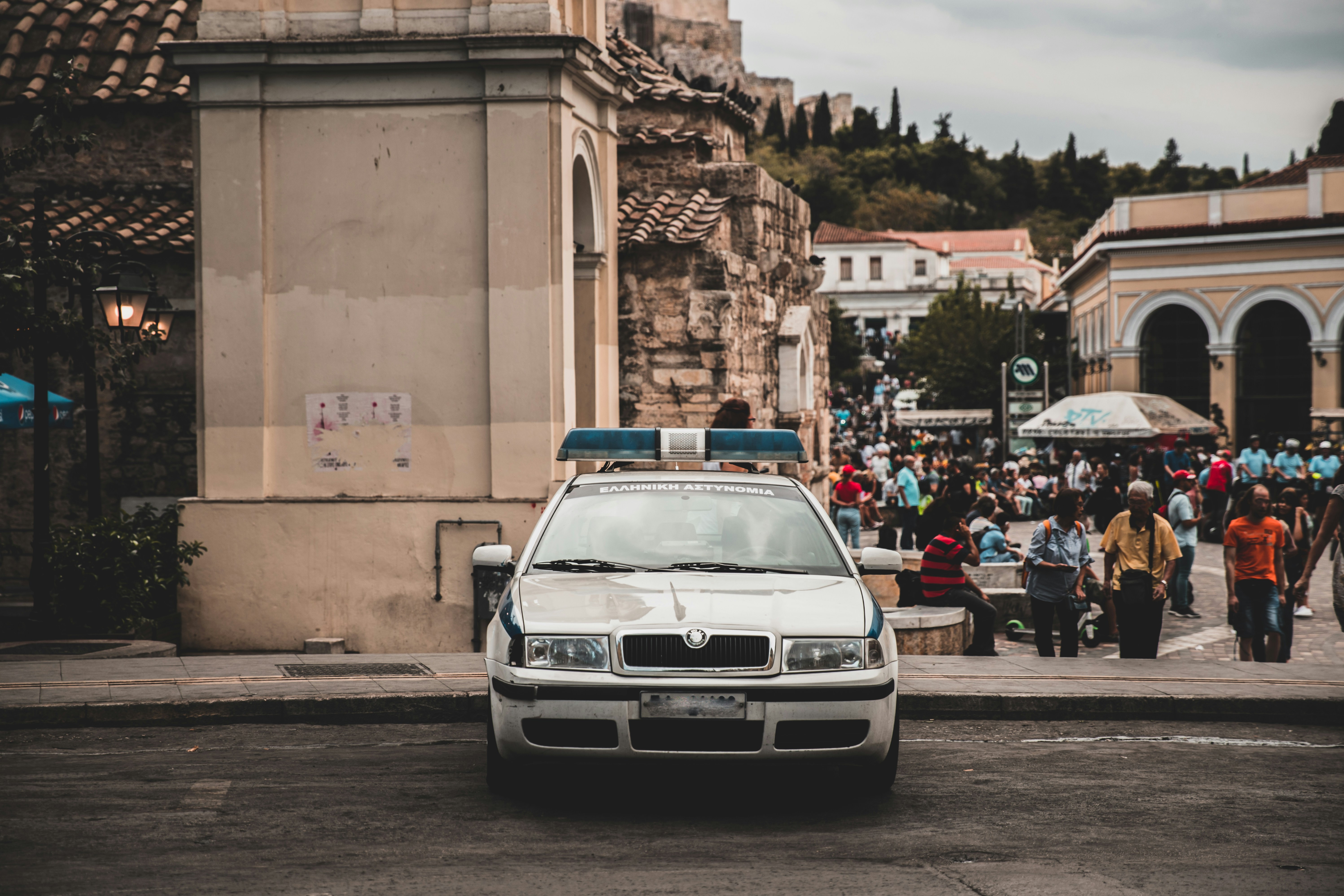 Blue Beacon in an Ancient Piazza: Patrol Amid a Crowded Town Square