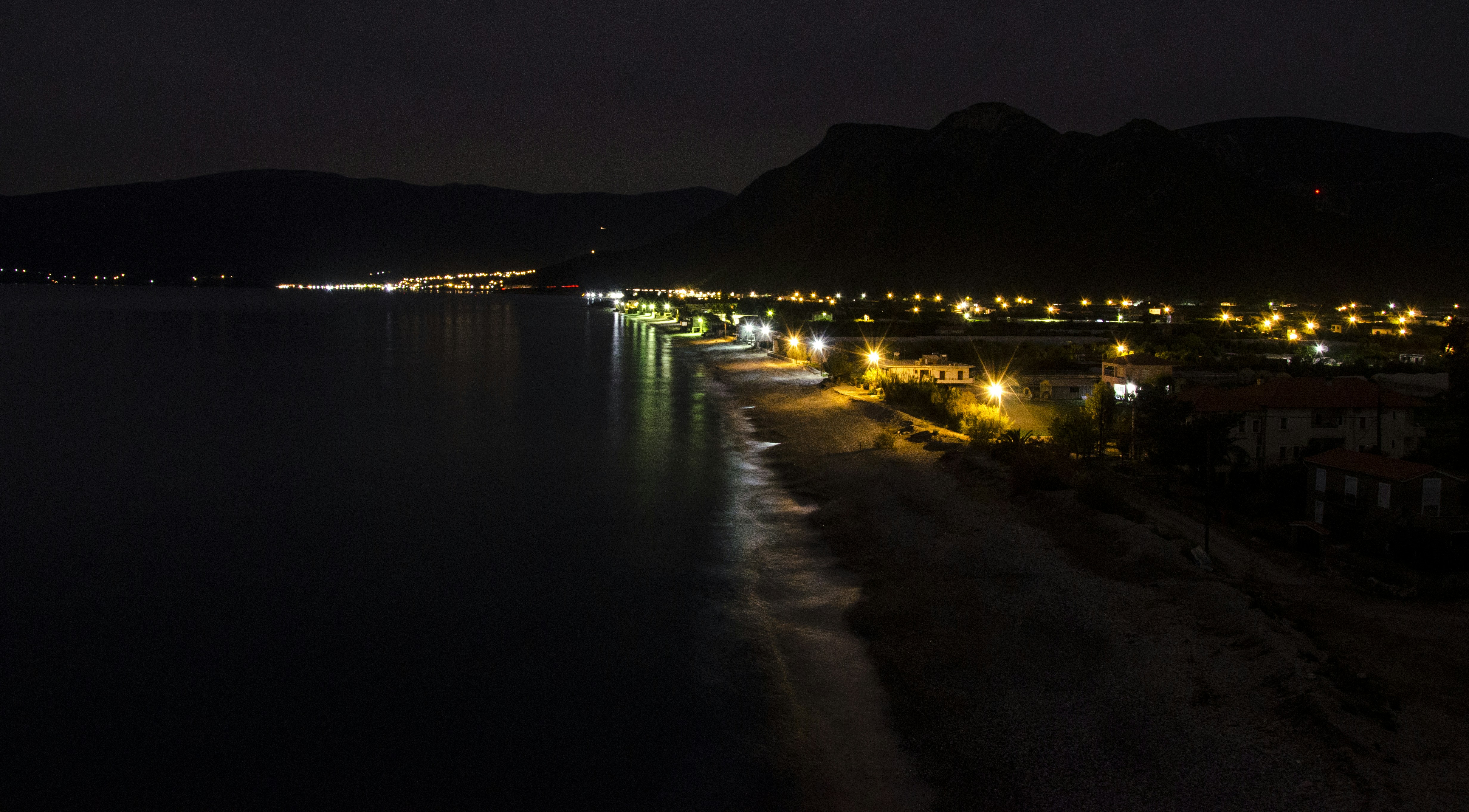 A night time view of a beach with lights on photo – Free Nature Image ...