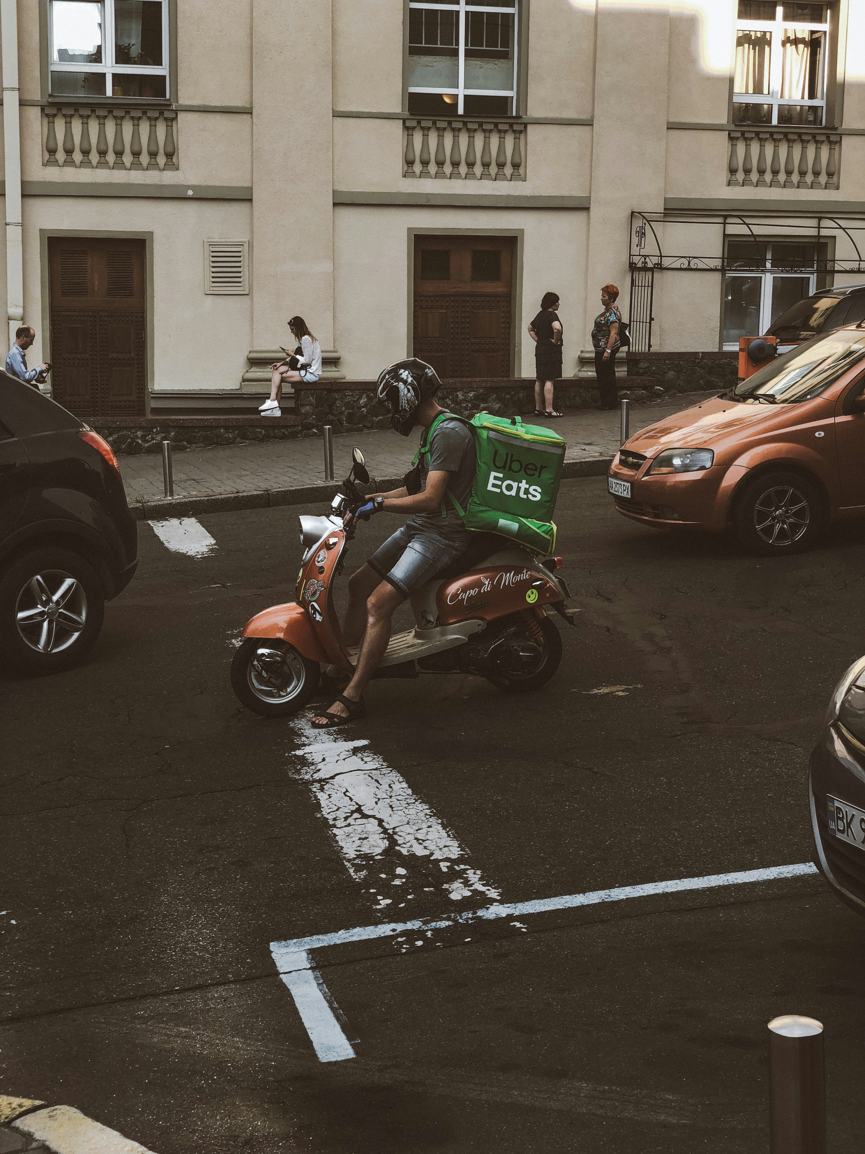 Urban Delivery in Motion: Scooter and Uber Eats Bag Under City Light