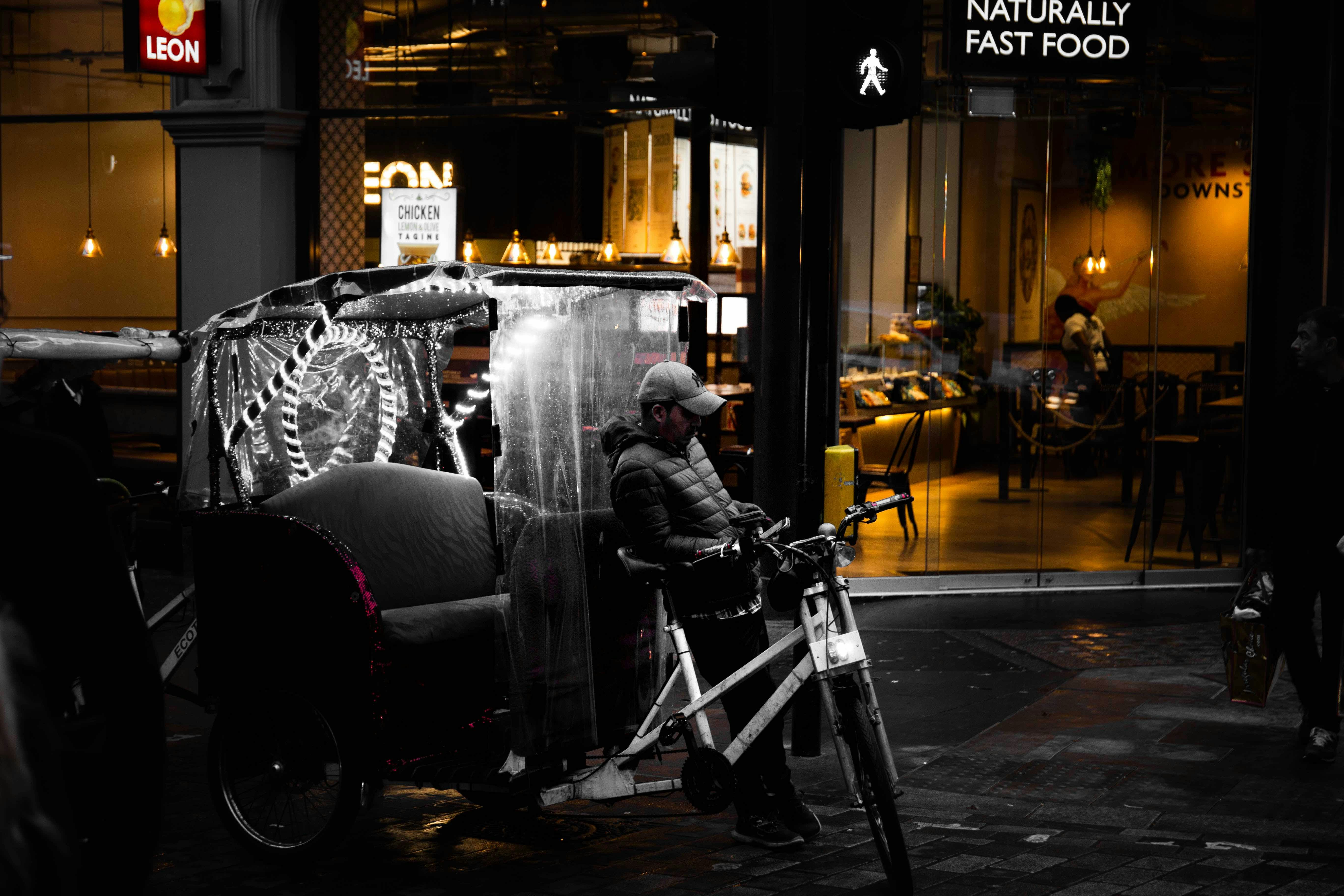 Night Pedicab by the Glass-Front Café: Stillness in Motion