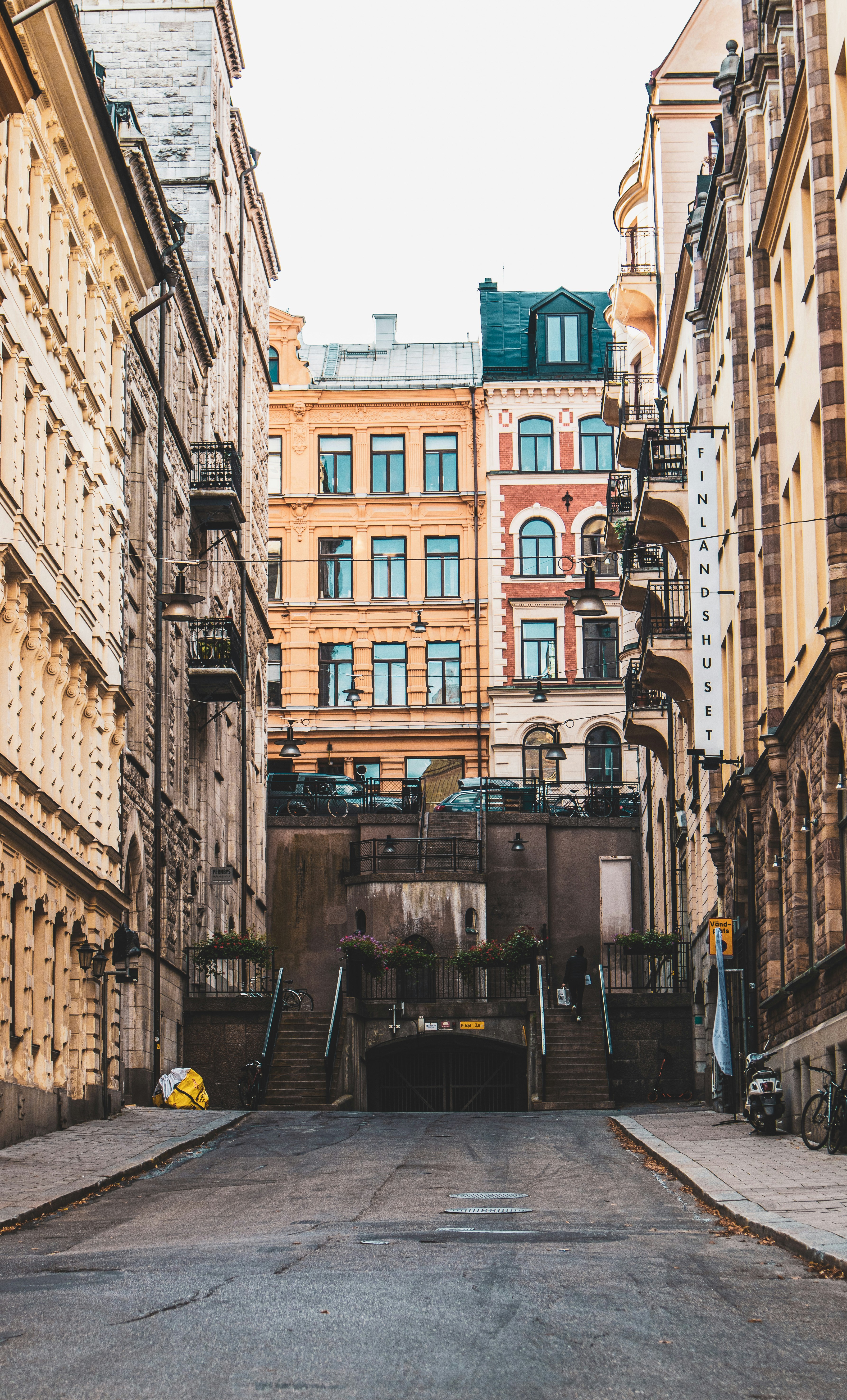 Gray concrete road in between high-rise buildings during daytime photo ...