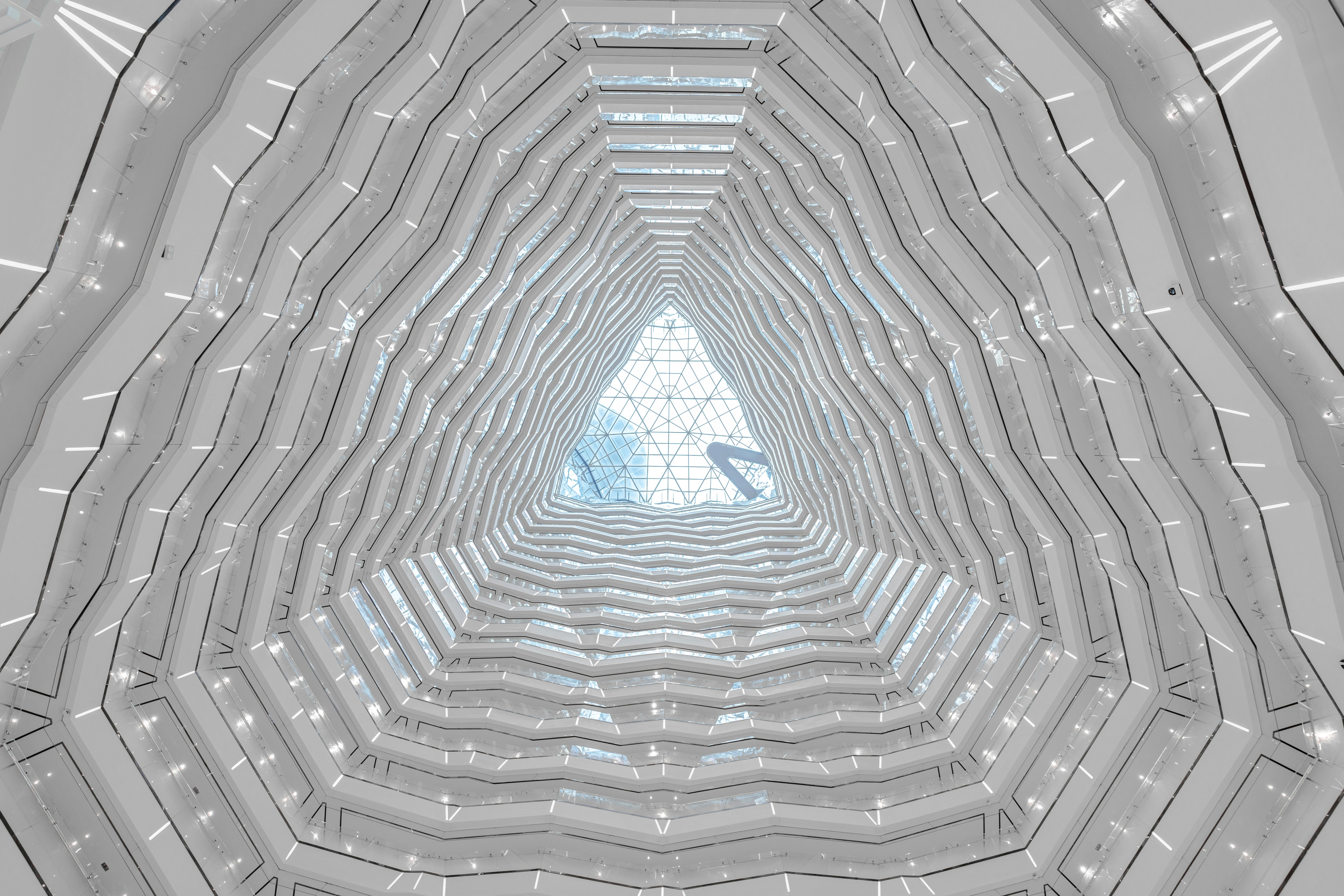 Skyward Lattice: Converging white facets toward a pale skylight