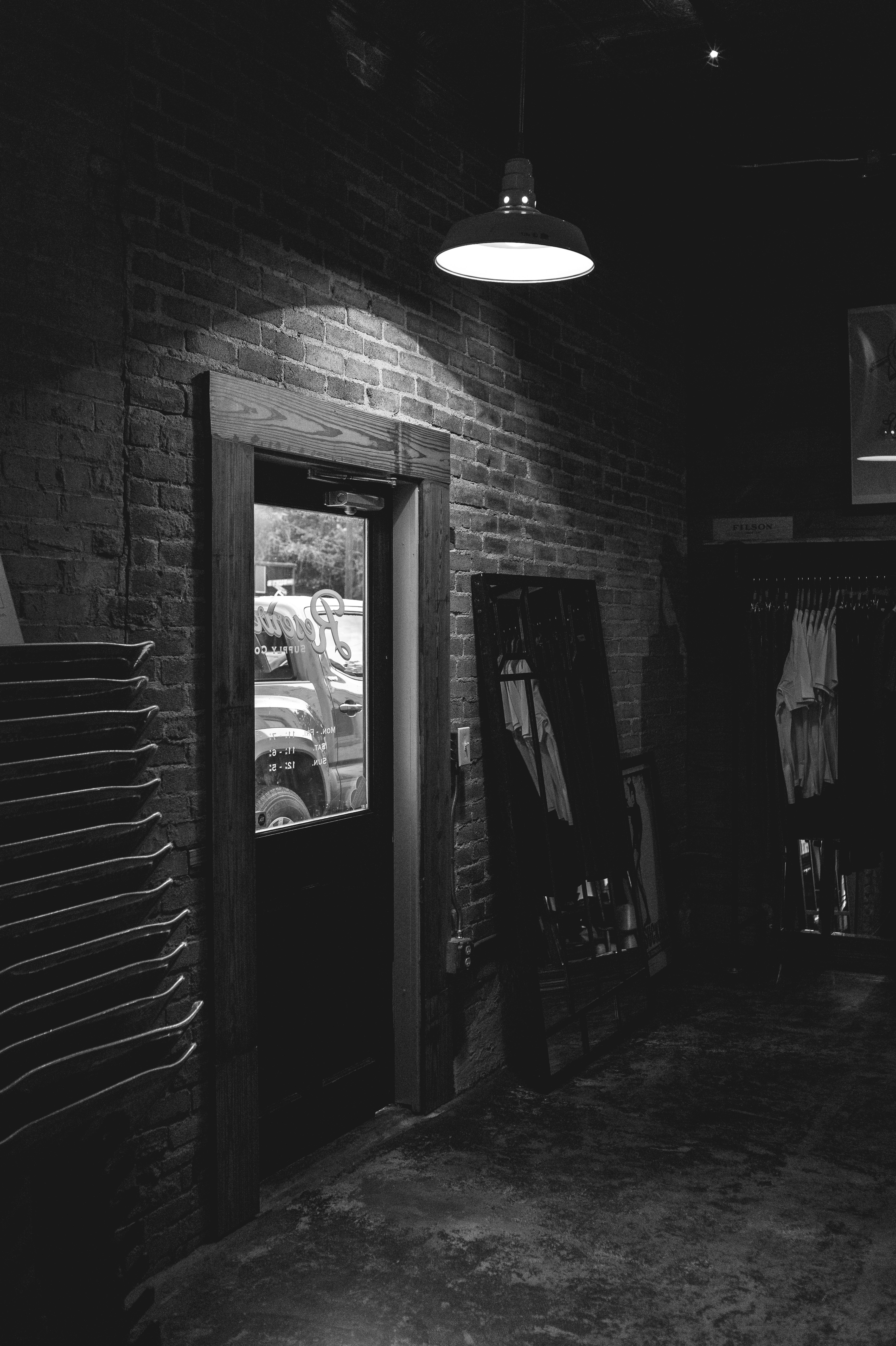 A dimly lit doorway framed by rustic brick walls, leading to an unseen world beyond. The atmosphere is enhanced by shadows and soft lighting.