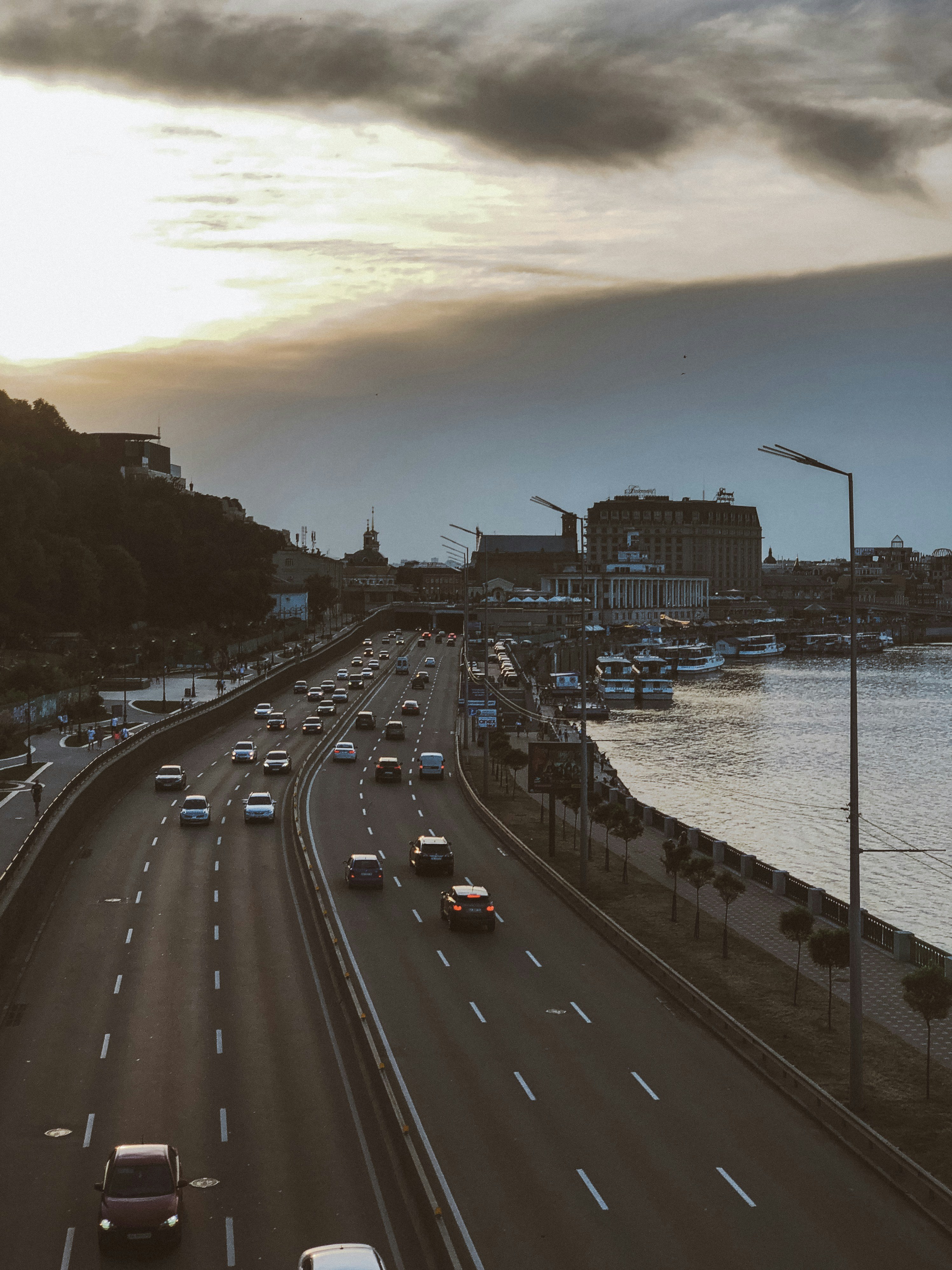 Dusk Convergence on the Riverside Highway: Traffic, Water, and Cranes
