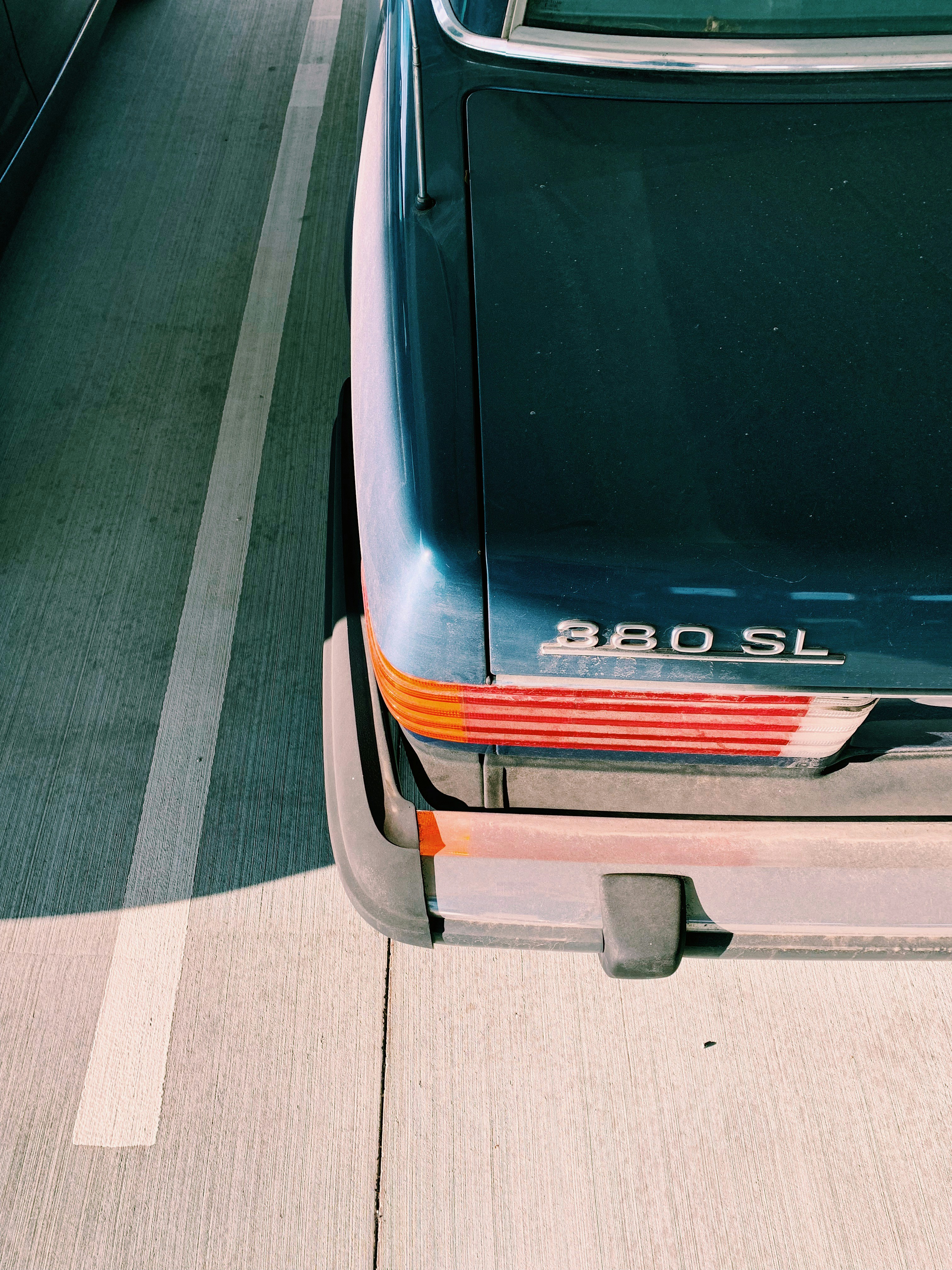 Teal Relic: A 380 SL Framed by Parking-Lot Stripes