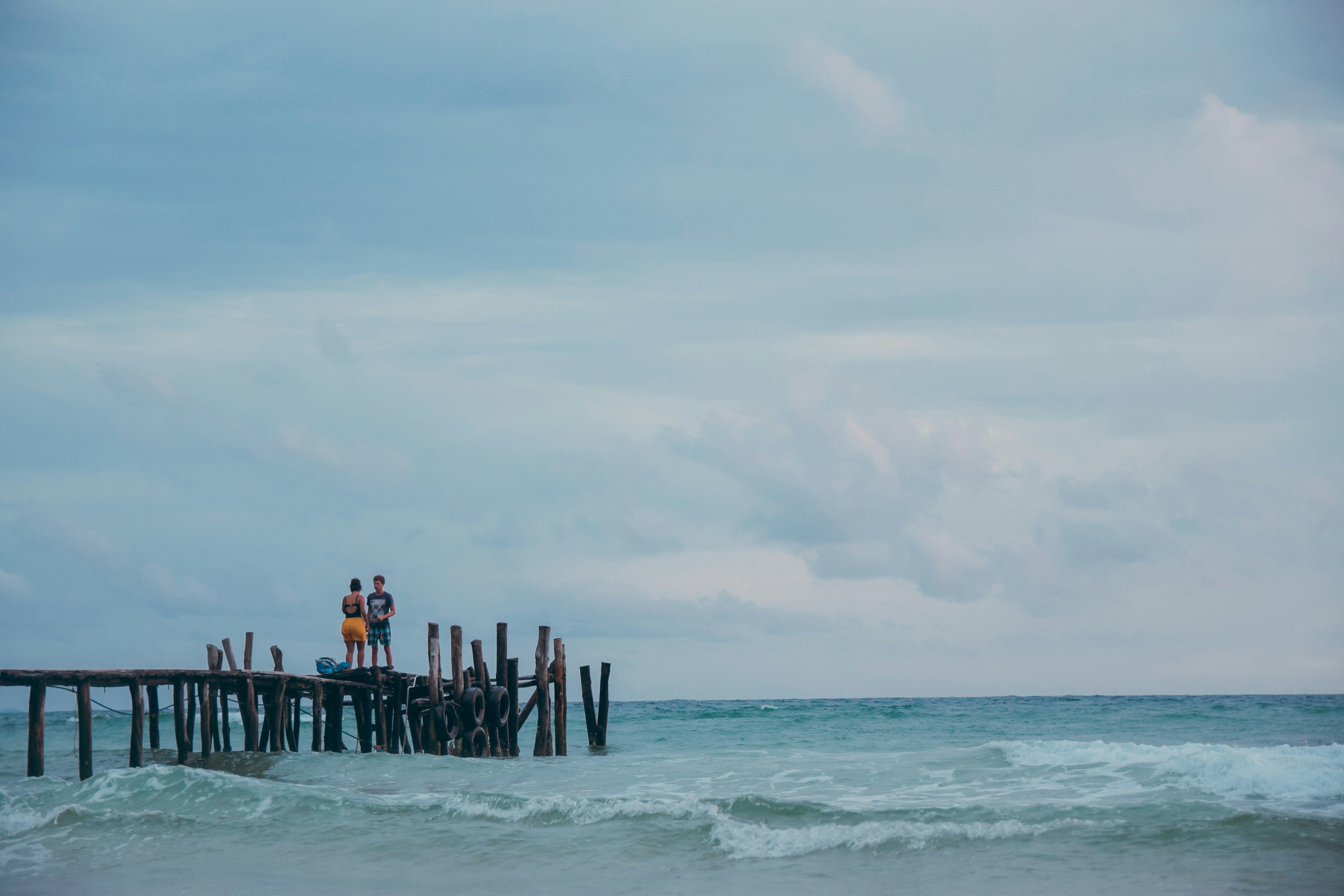 Lonely Pier at Sea: Figures on the Weathered Docks at Dusk