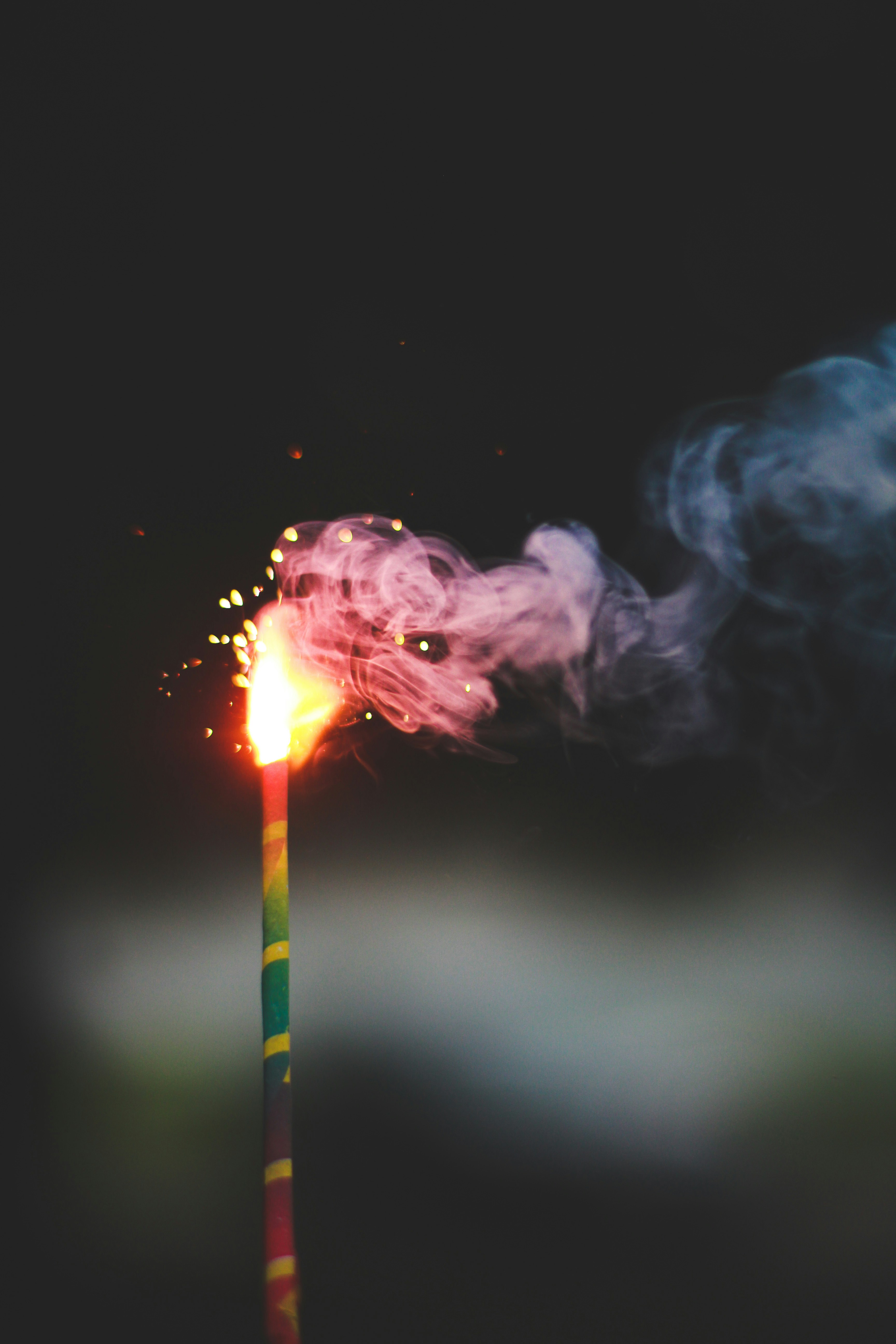 Twilight Ember: a color-striped sparkler painting the glow with pink smoke
