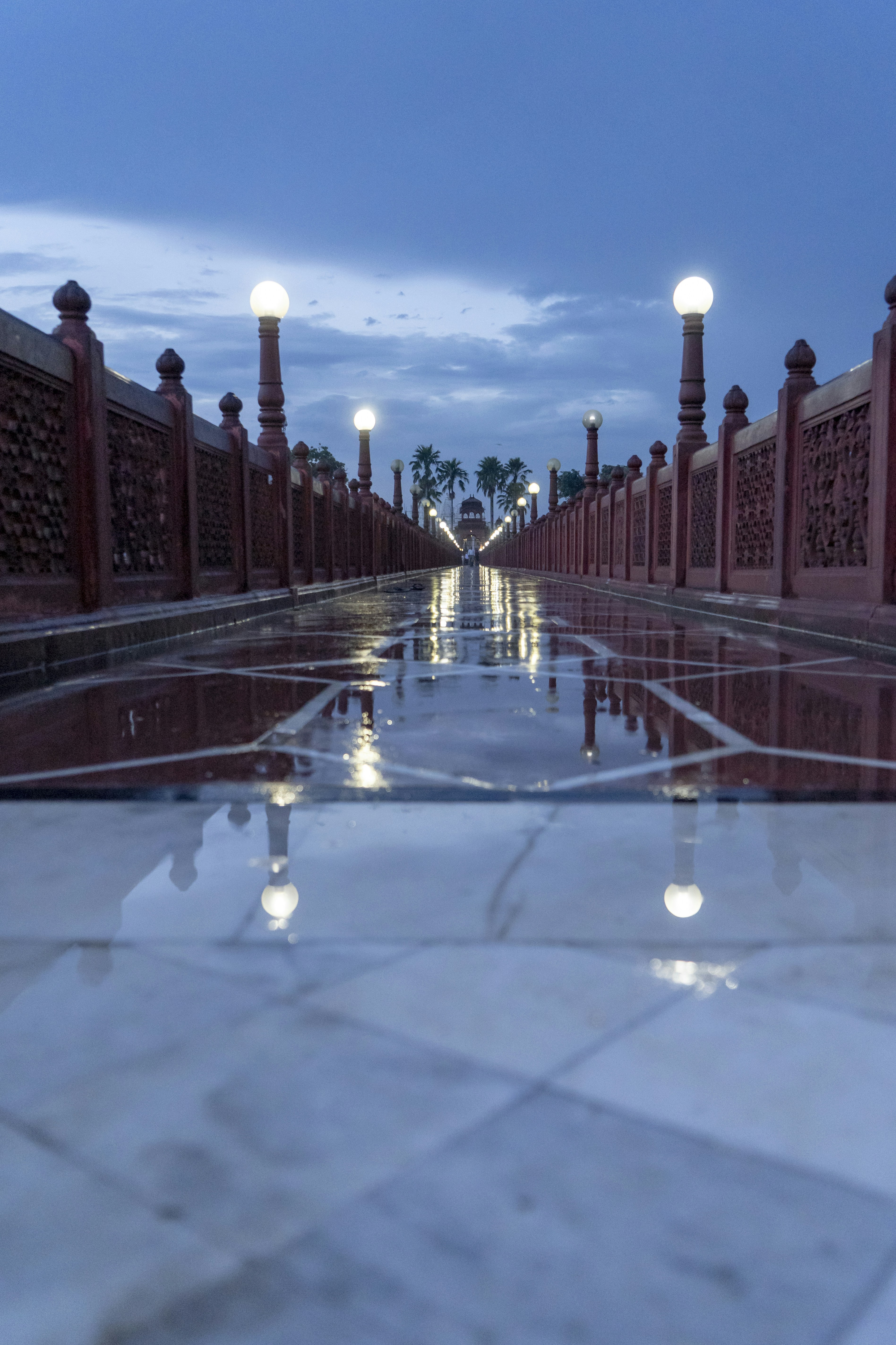 Vanishing Line of Light: Reflections Along a Red Brick Bridge