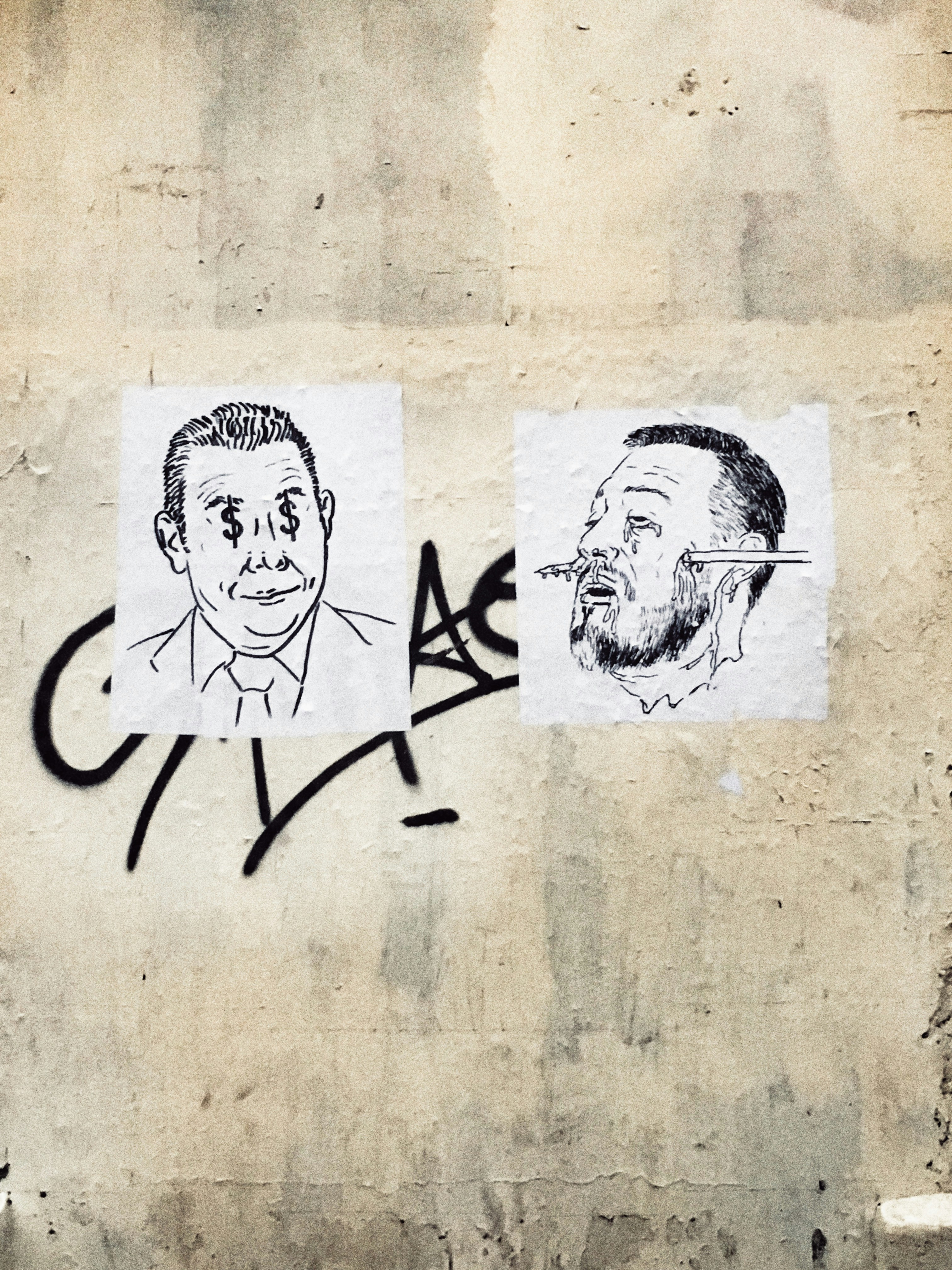 Stickered Faces on Weathered Wall
