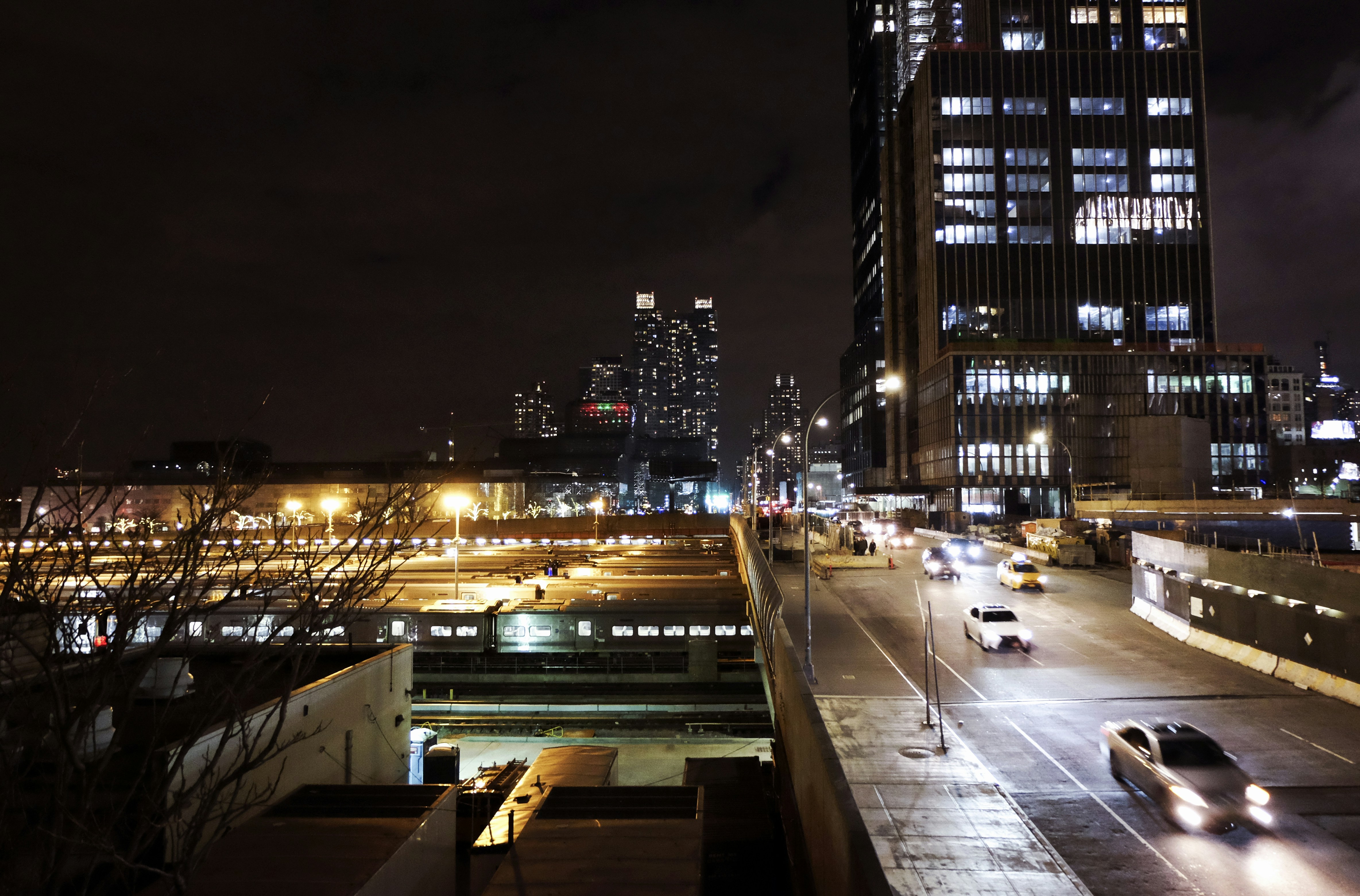 City skyline illuminated at night with bustling streets and towering buildings. The scene captures the essence of urban life after dark.