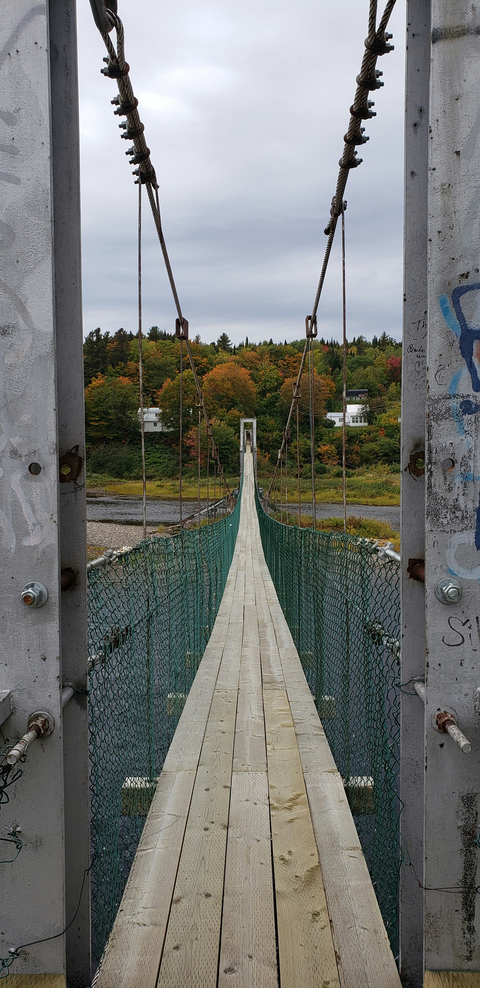 Span of Wood and Water: A Suspended Bridge Toward Autumn's Riverbank