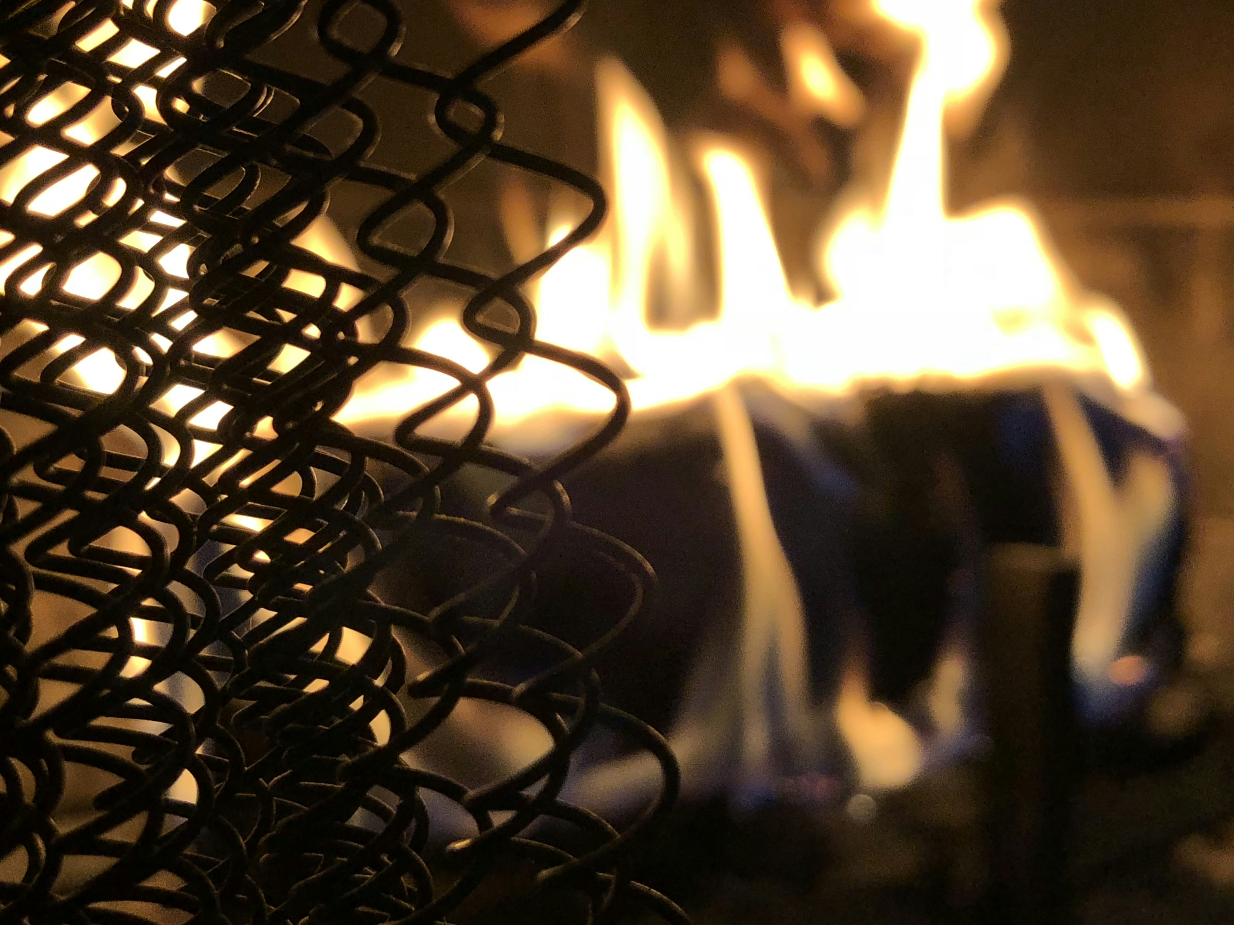 Flames flicker against a backdrop of twisted metal, creating a warm and dynamic contrast. The interplay of light and shadow enhances the scene's depth.